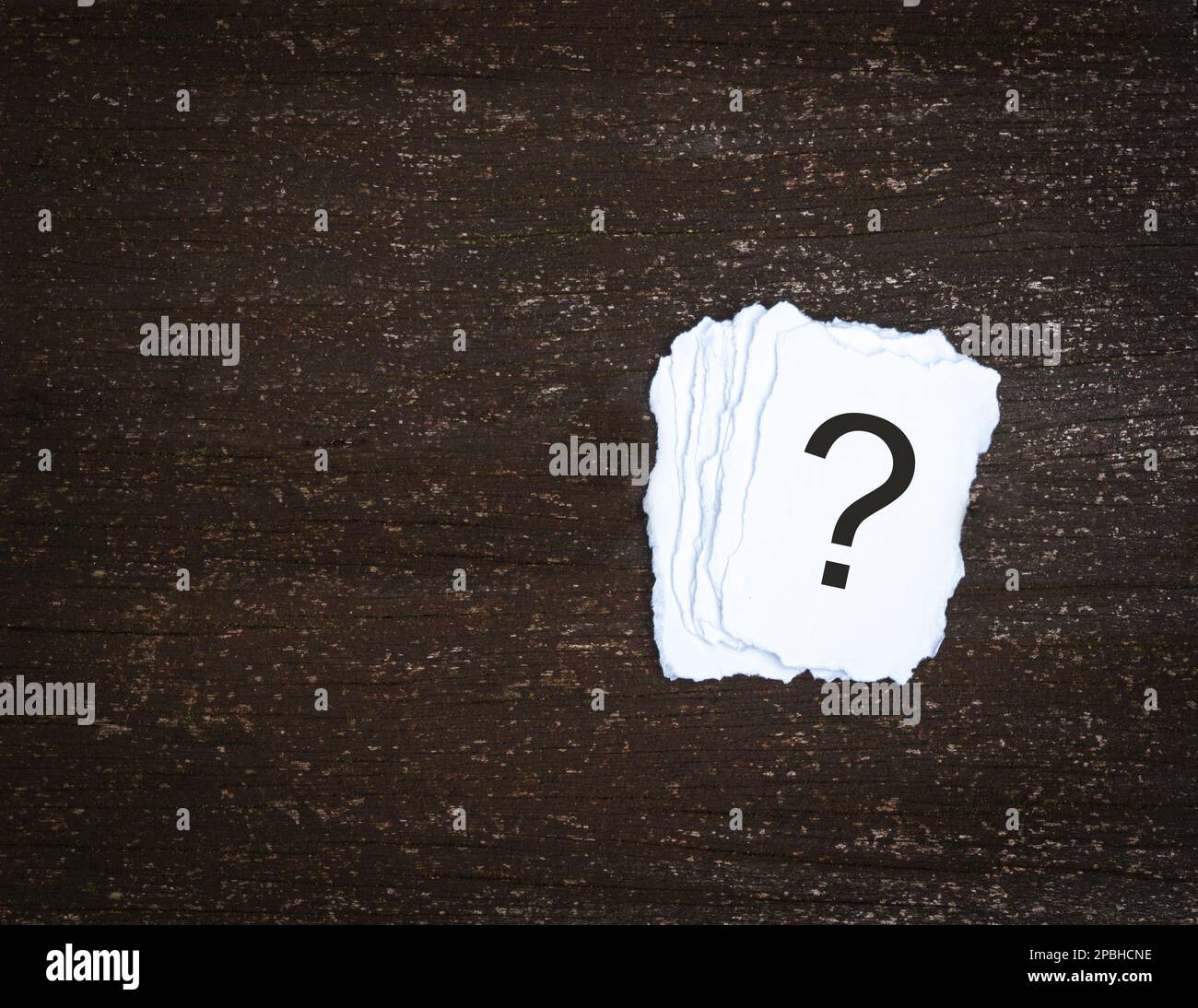 Question mark stack of torn papers on grunge wood table. Confusion or ...