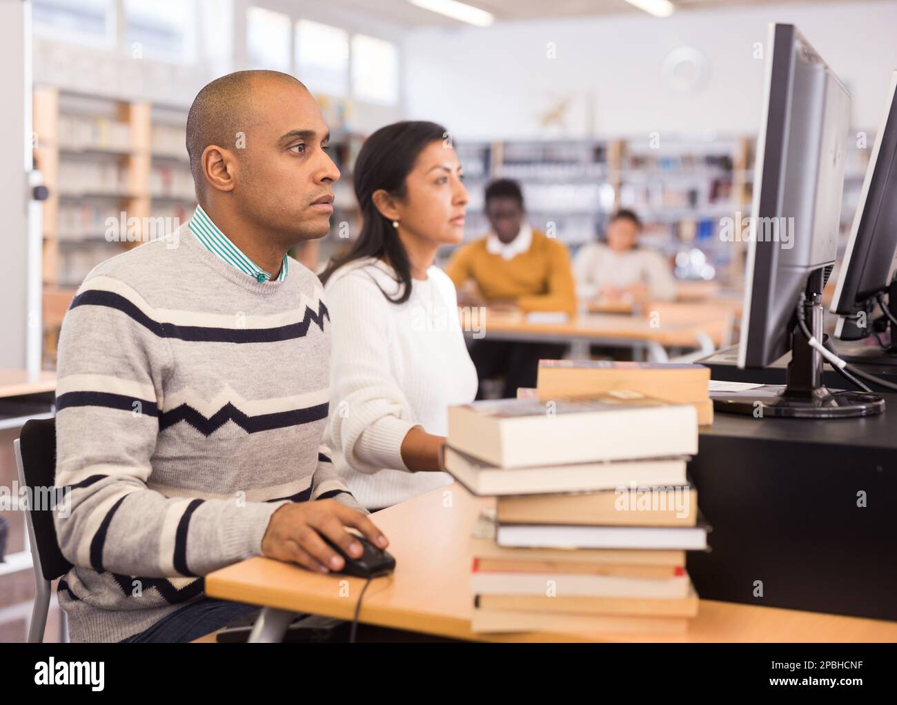 Young adult man studying in computer class Stock Photo - Alamy