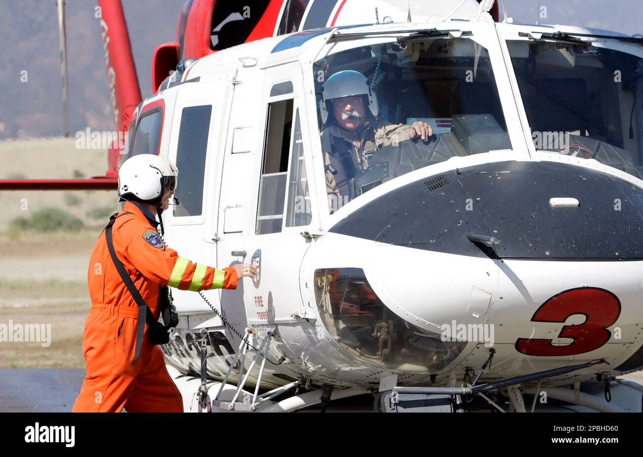 Los Angeles city fire helicopter pilot John Gibbs, right, talks with ...