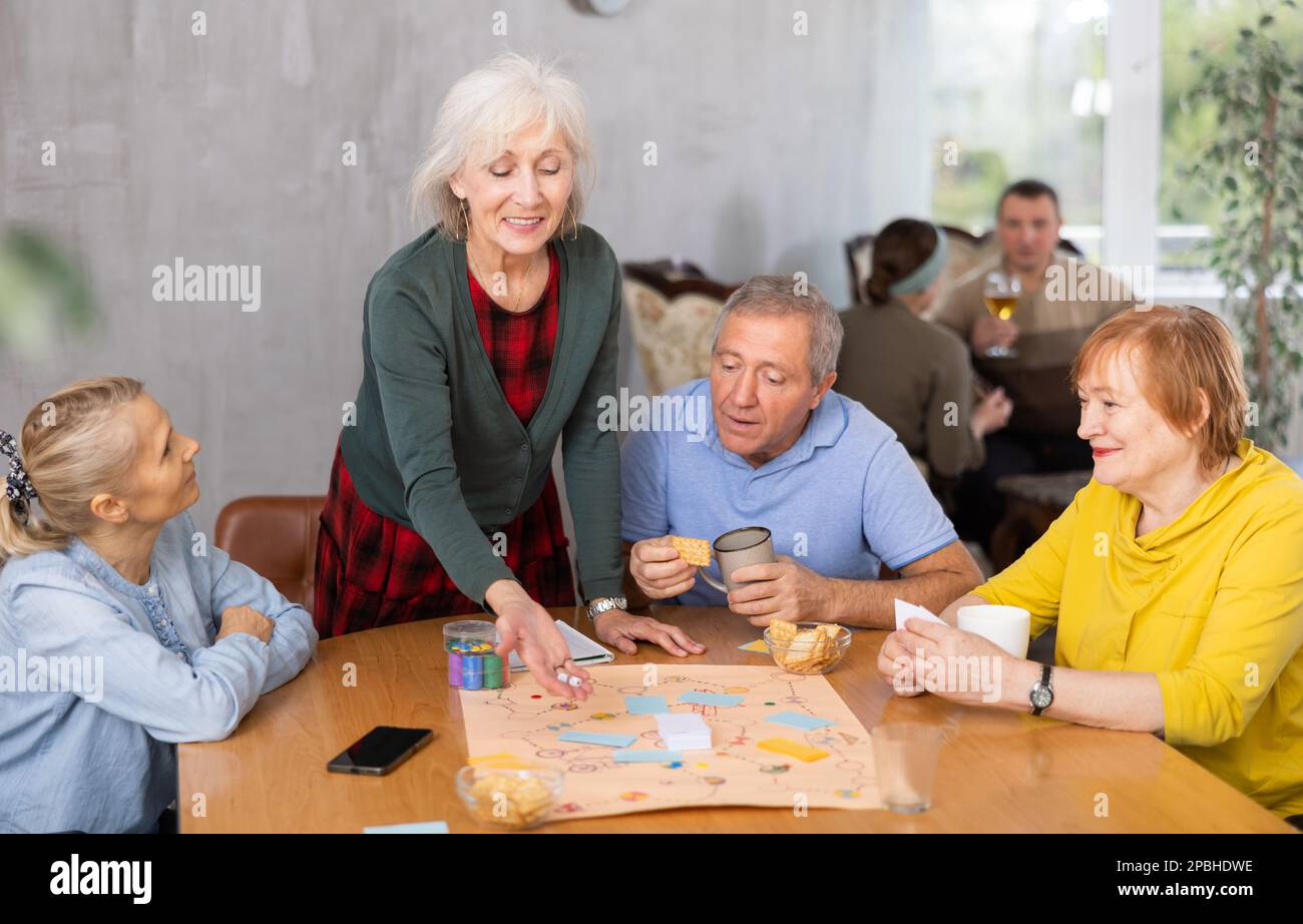 Older men and women playing board game together Stock Photo - Alamy