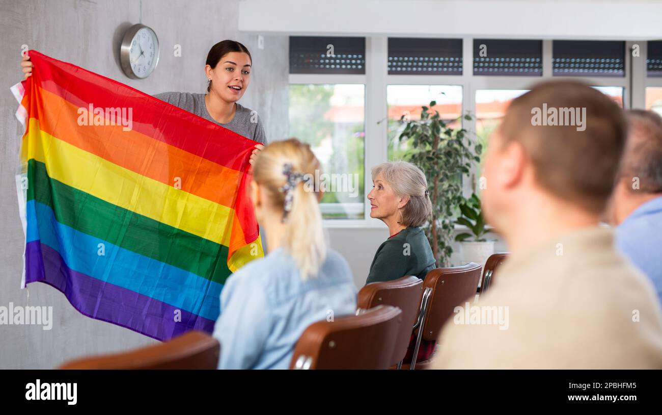 Portrait of young female teacher conducting lesson for adult students ...