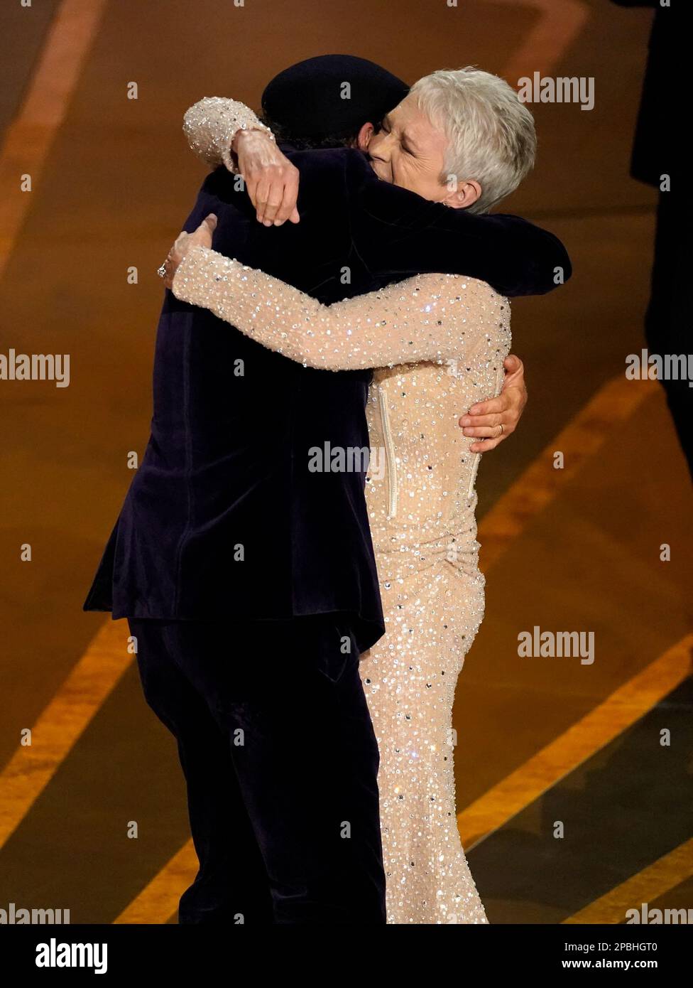 Troy Kotsur, left, hugs Jamie Lee Curtis as she accepts the award for best performance by an ...