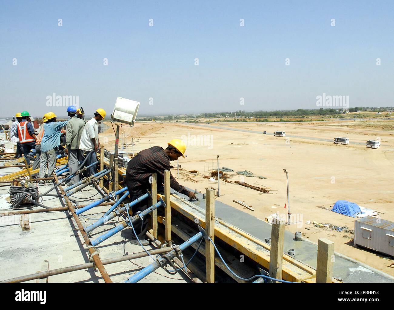 Indian workers are seen engaged in a construction activity at the GMR ...