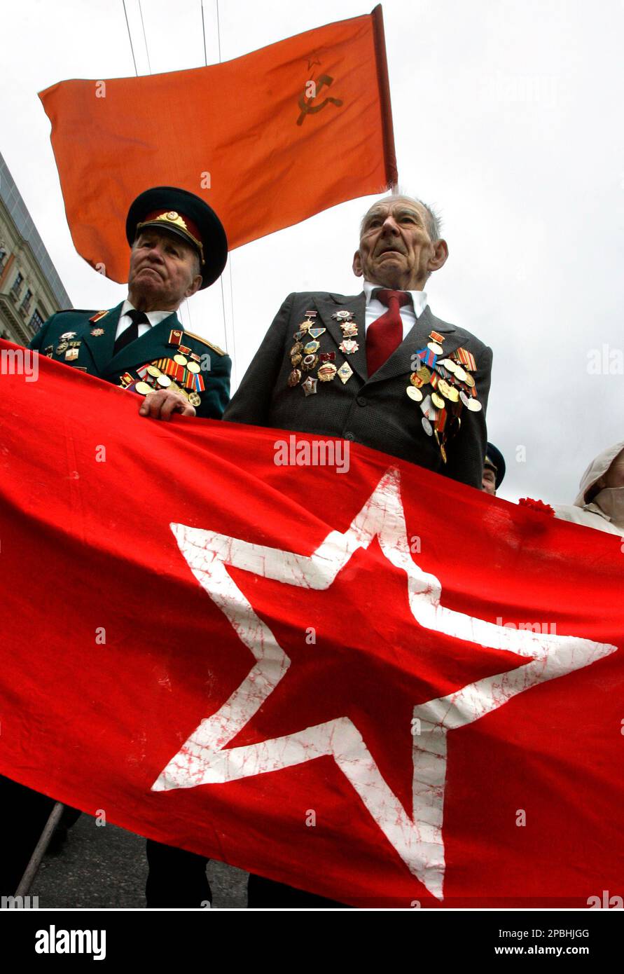 Russian World War II veterans carry a Soviet flag as they celebrate ...