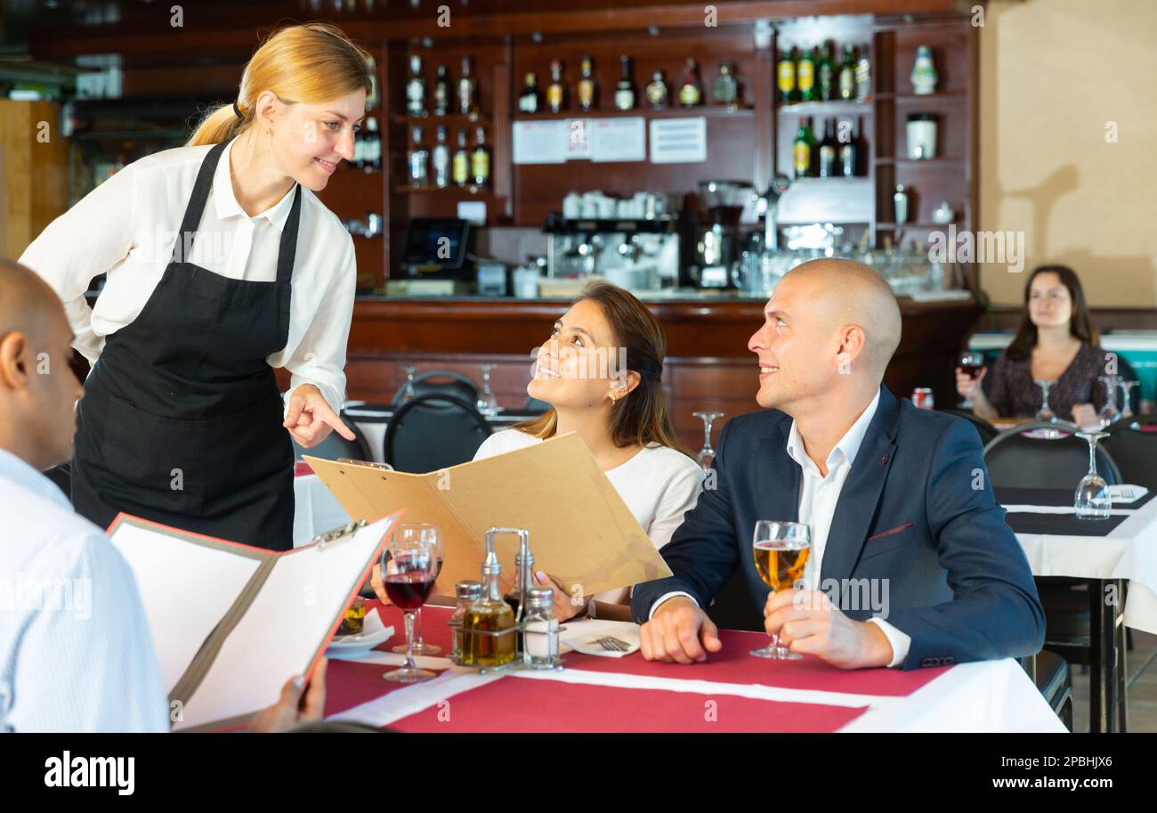 Woman taking menu from waitress hi-res stock photography and images - Alamy