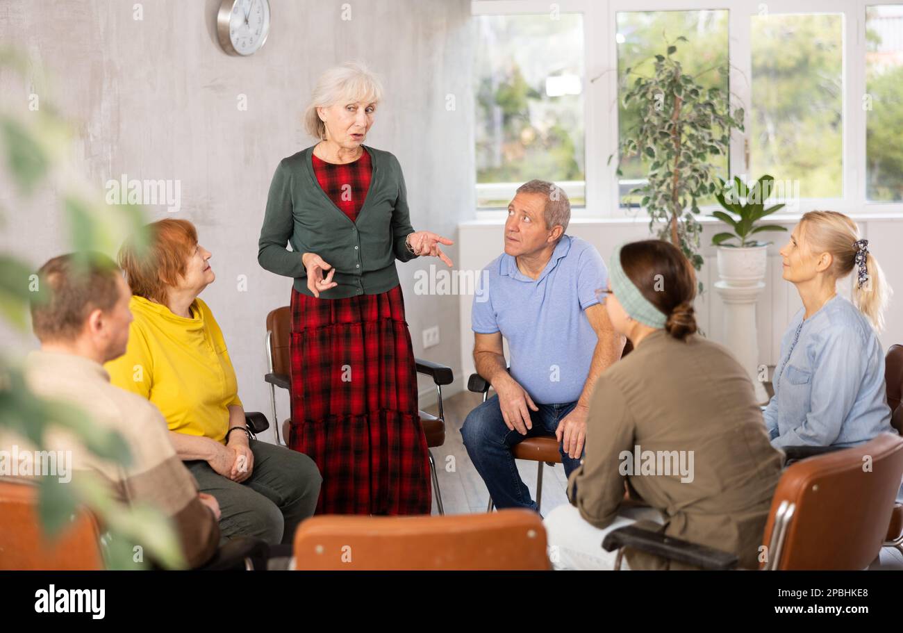 Aged woman conducting language speaking club for older adults Stock ...