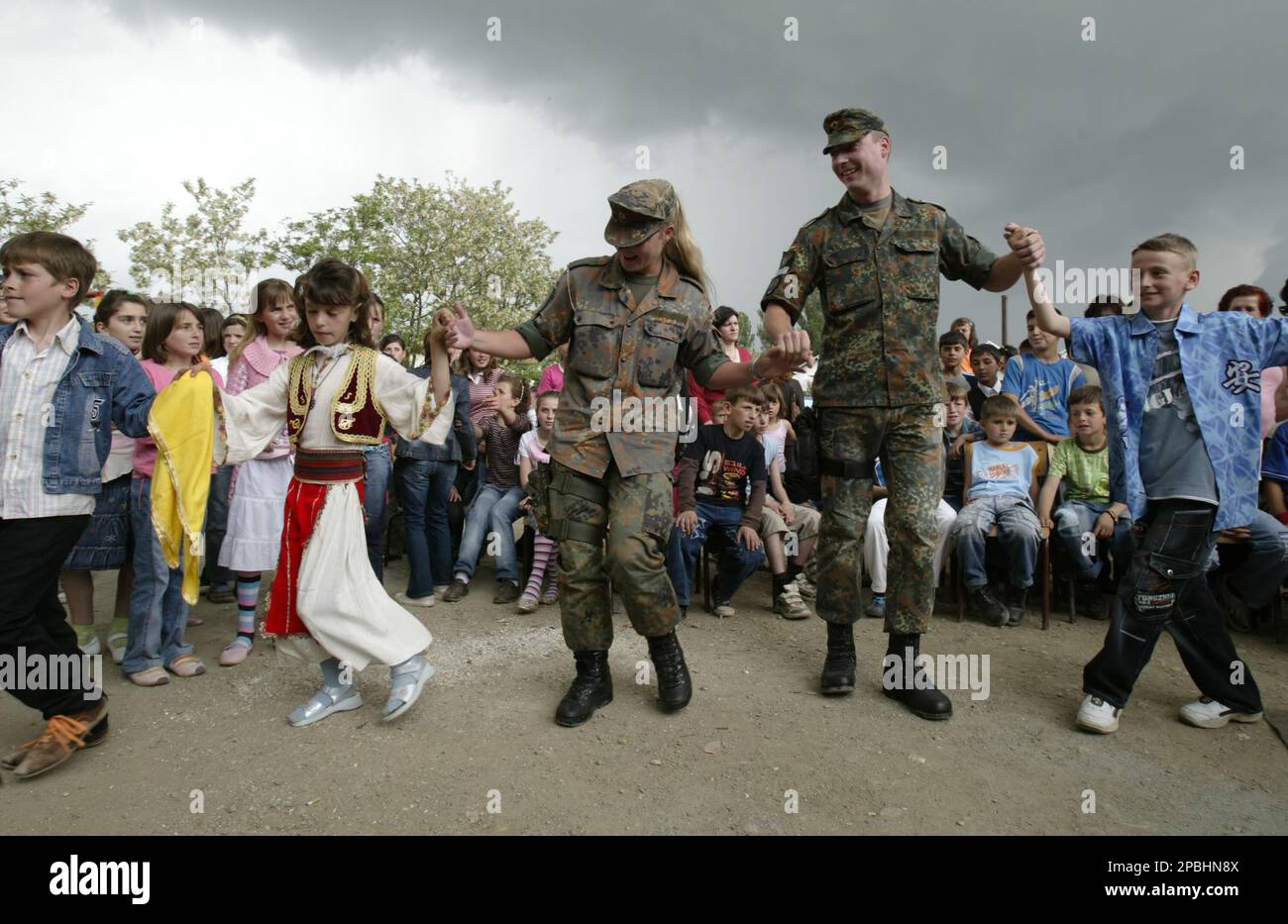 German peacekeepers join Kosovo Albanian children performing a dance ...