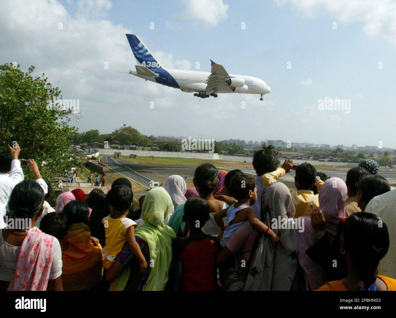 People watch an Airbus A380 land at the Chatrapati Shivaji ...