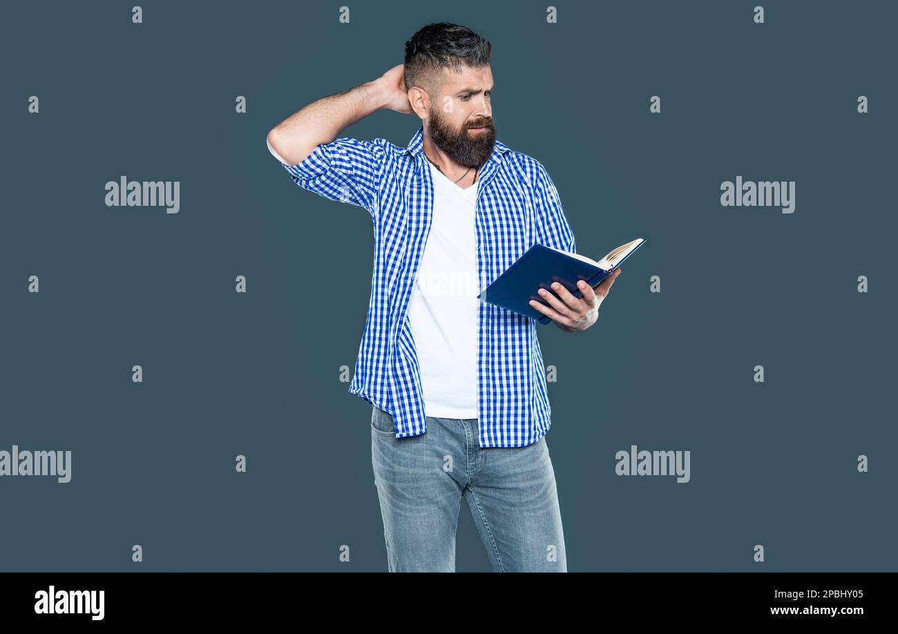 puzzled bearded man reading book on grey background Stock Photo - Alamy