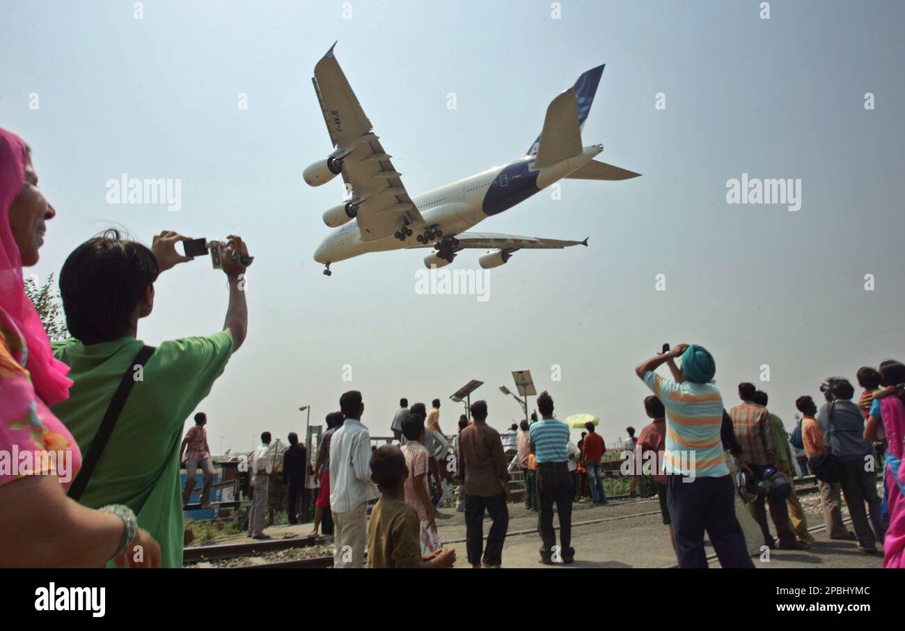 People look on as an Airbus A380 prepares to land at the Indira Gandhi ...