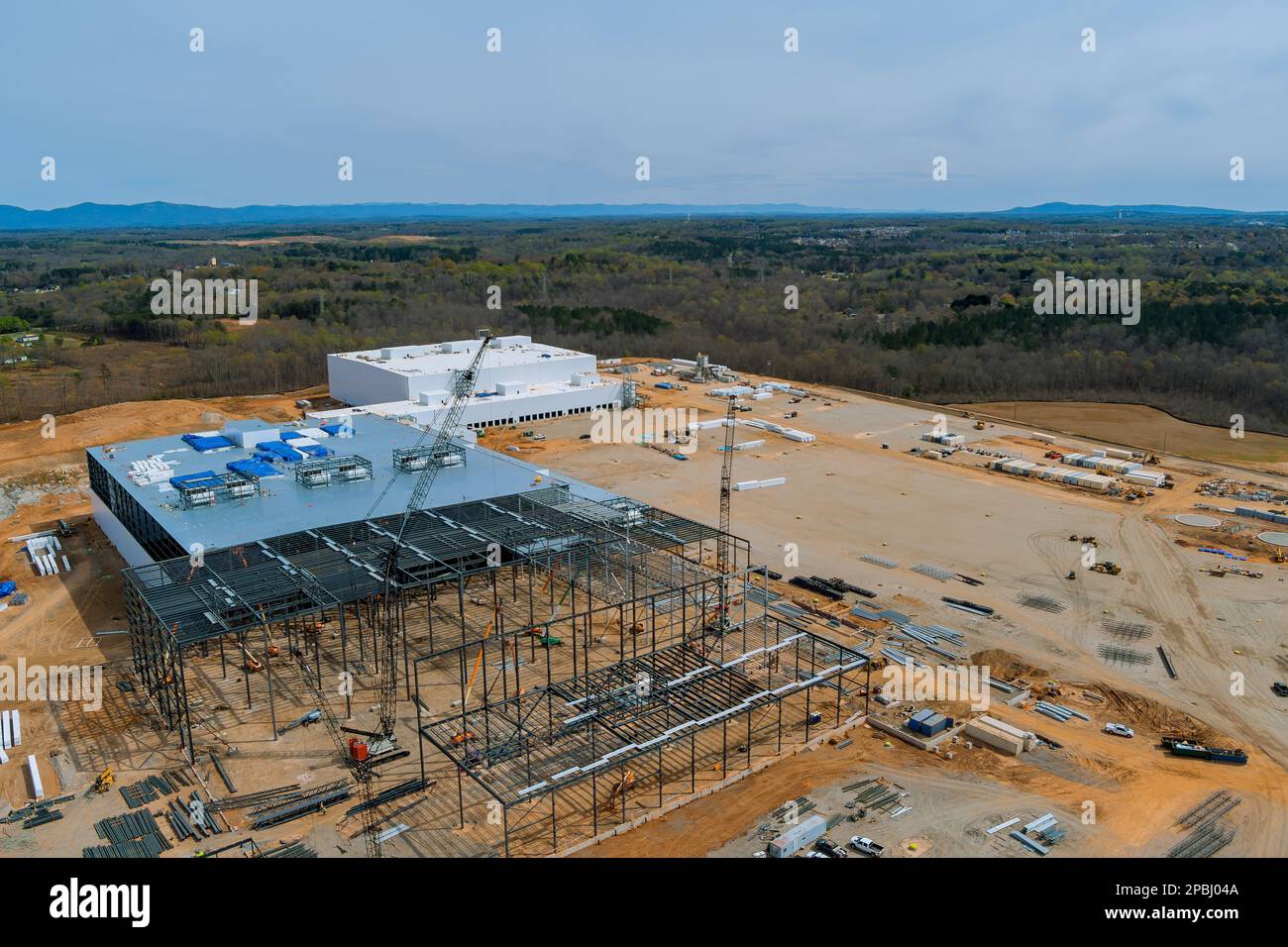 An industrial building is constructed use crawler cranes metal steel ...