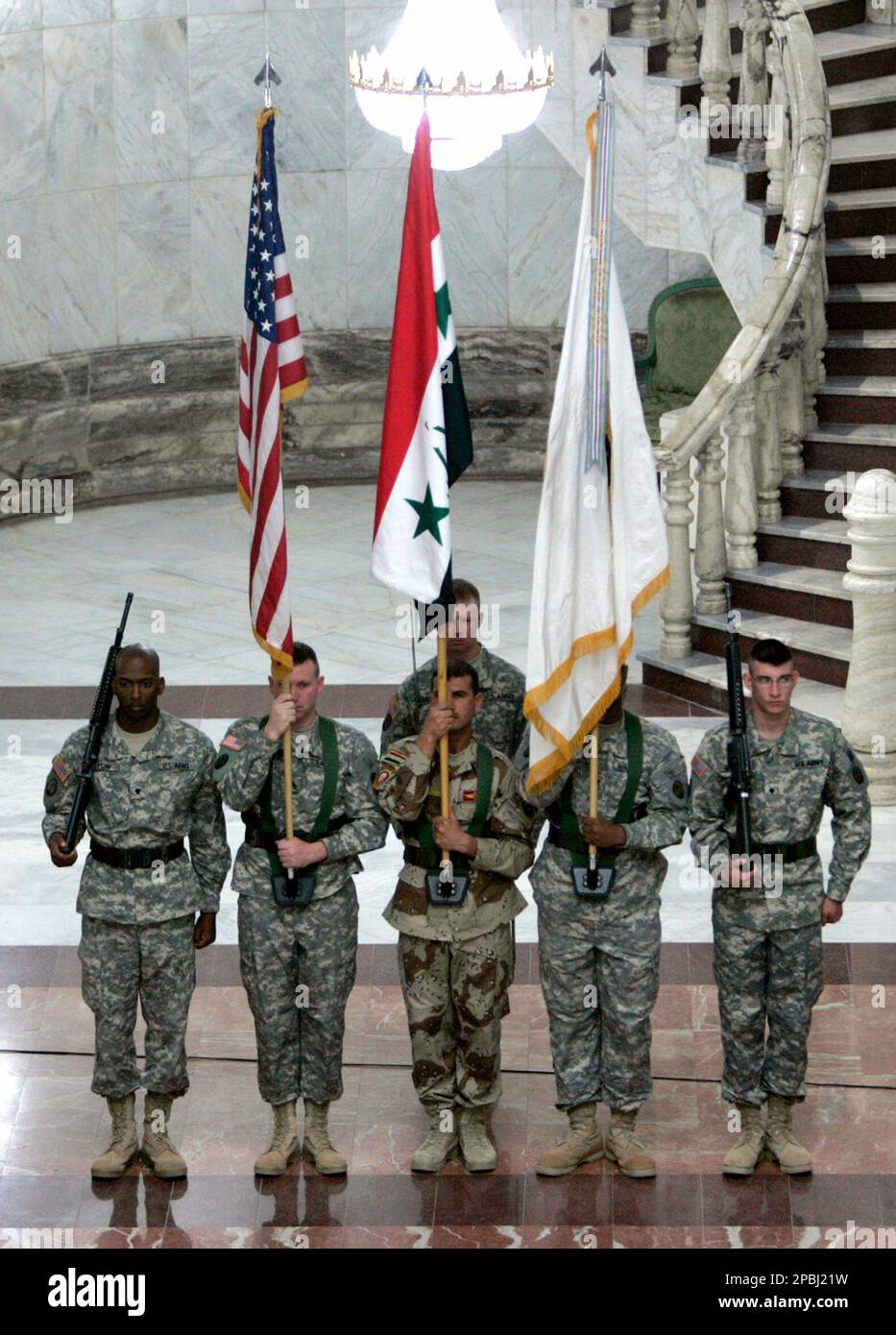 U.S.and Iraqi military colours guard stand at attention during a hand ...