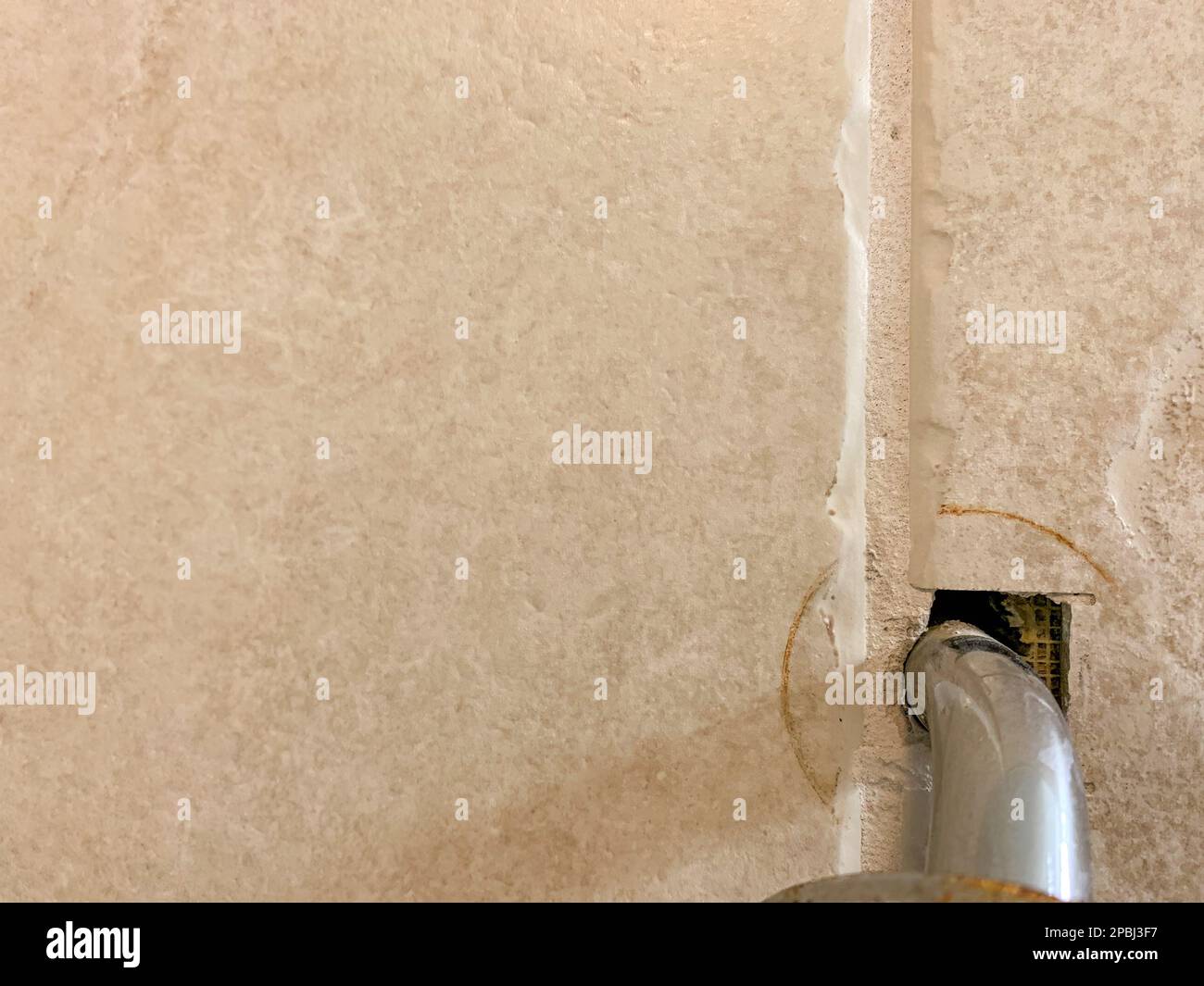 Hole cut into tile with a shower head protruding after installation ...