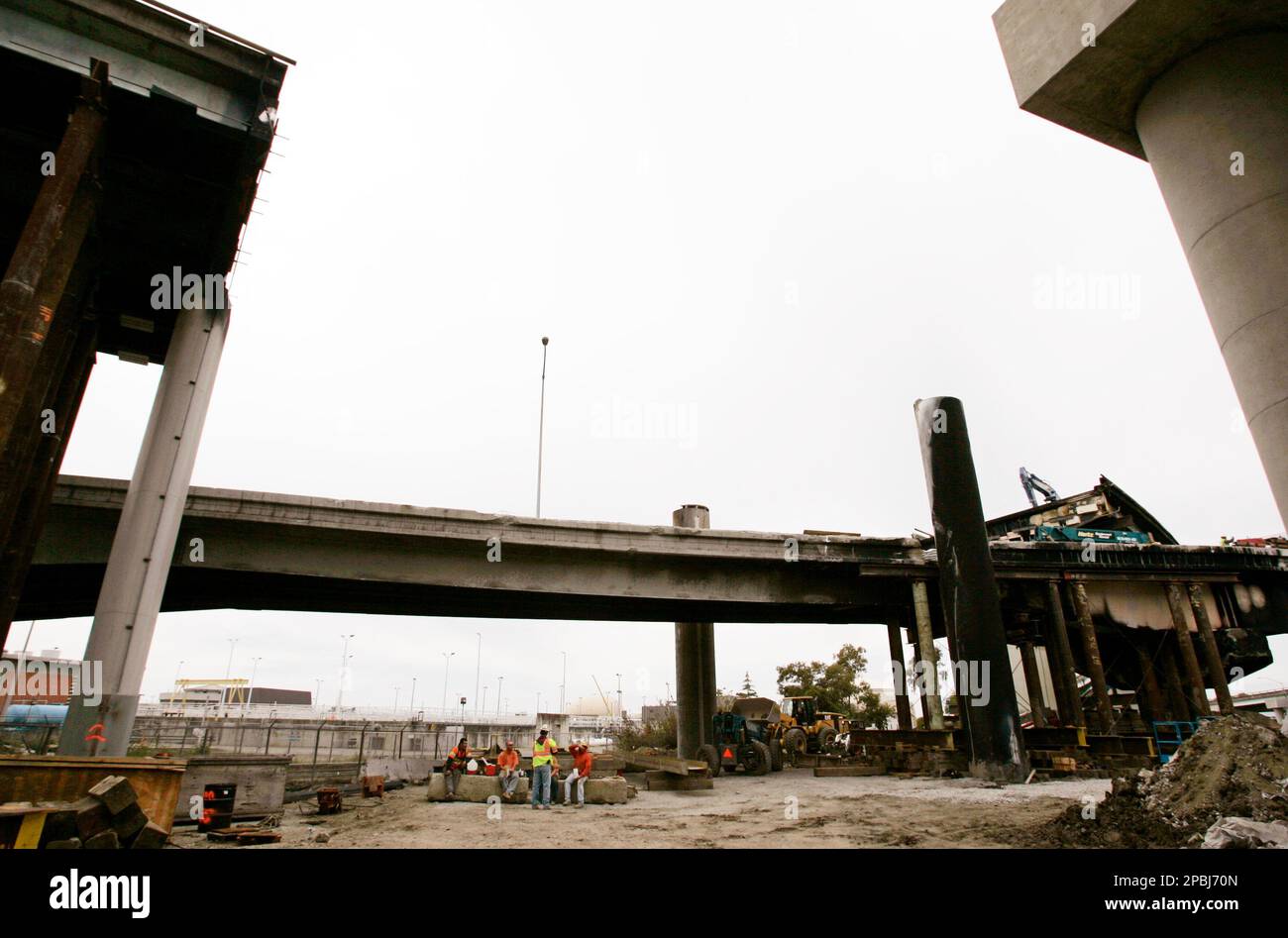 Workers take a break from repairing a collapsed freeway in Oakland ...