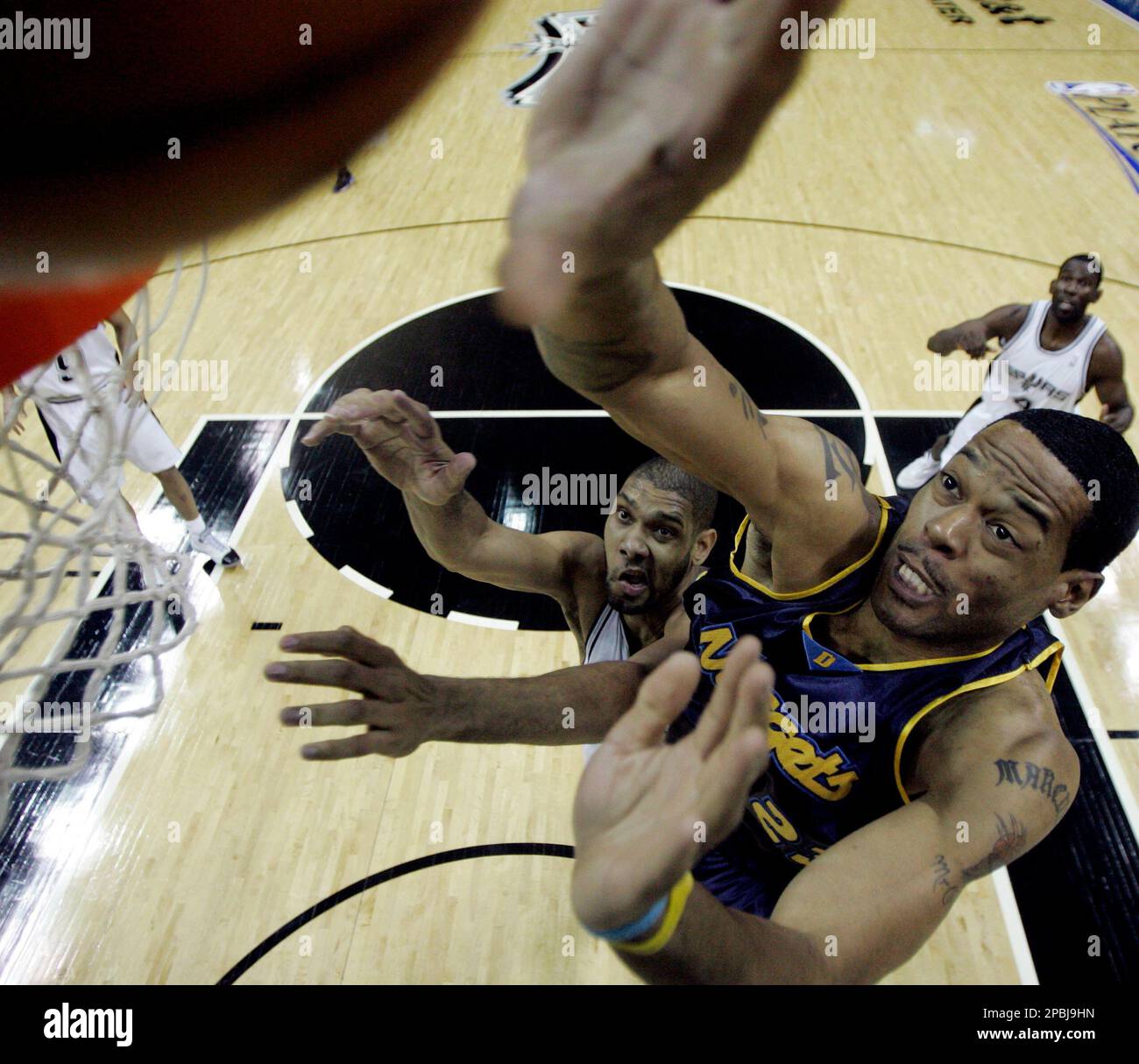 Denver Nuggets center Marcus Camby, right, scores over San Antonio ...