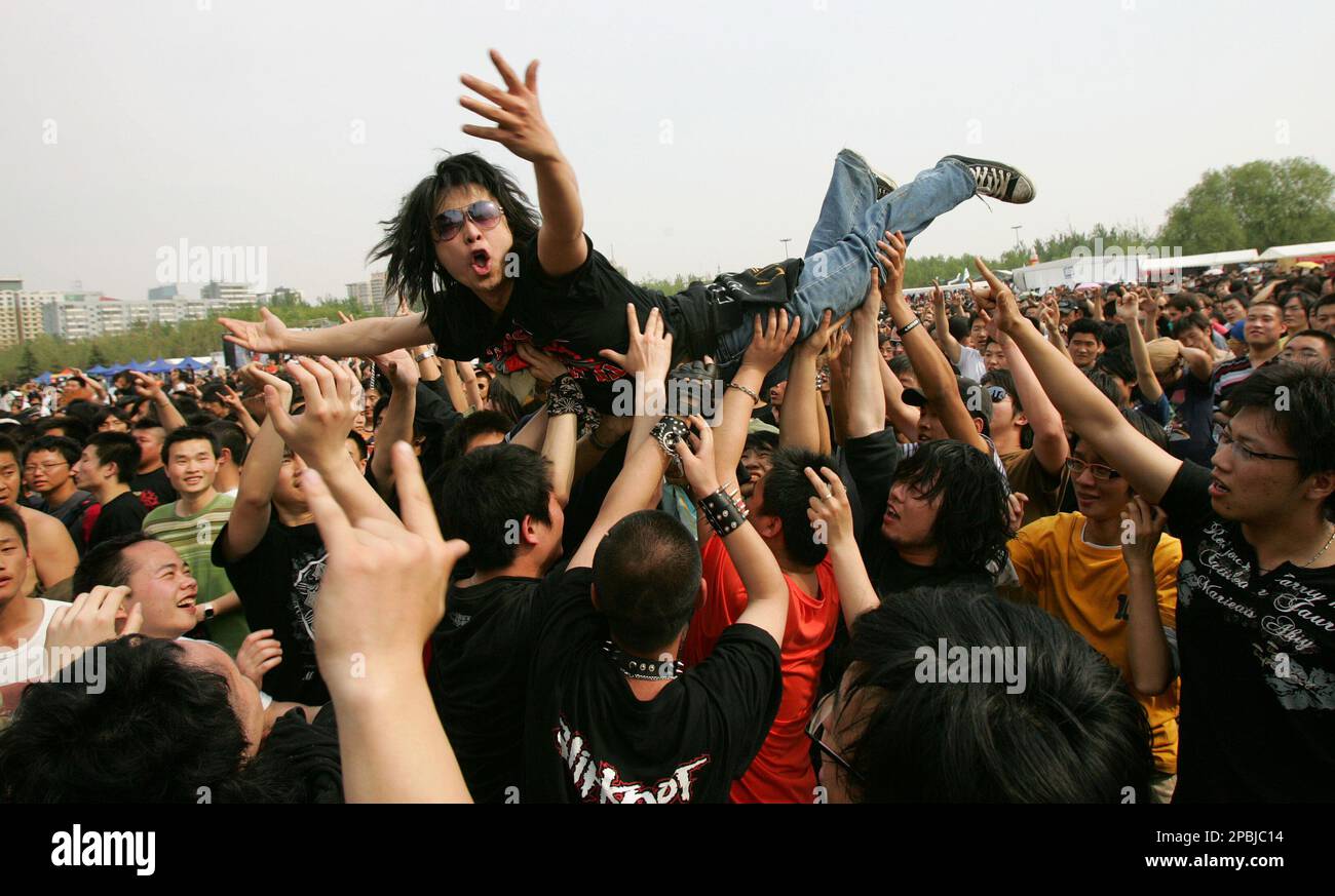 A rock fan surfs the crowd during a performance at the Midi Music ...