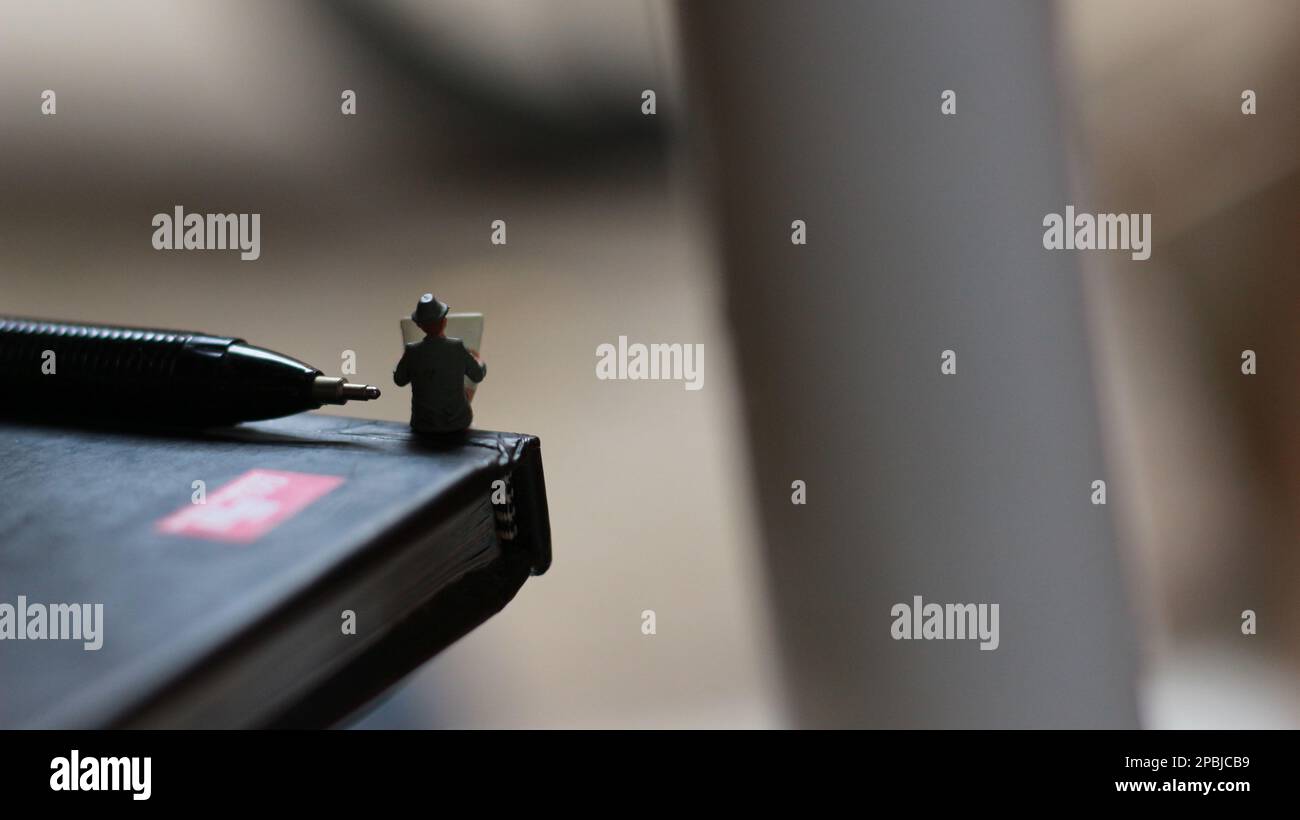 Small figure reading newspaper hi-res stock photography and images - Alamy