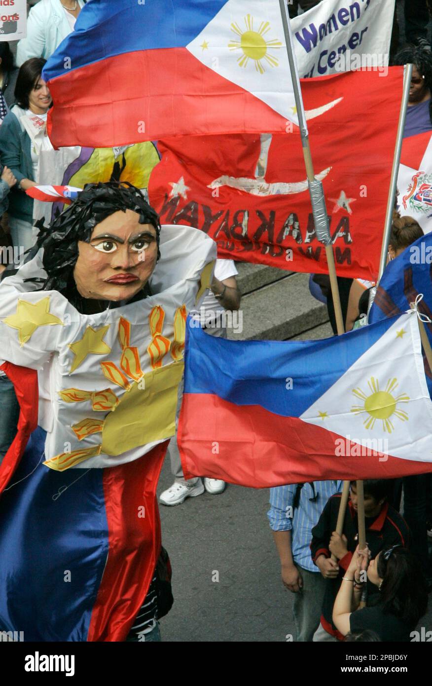 A giant puppet dressed in the colors of the Filipino flag is surrounded ...