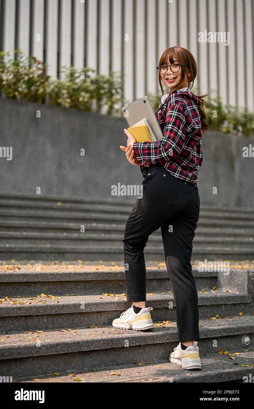 Portrait of a charming and smiling young Asian female college student ...