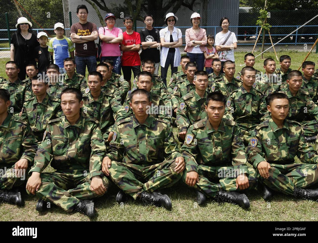 Visitors pose with People's Liberation Army (PLA) officers during an ...