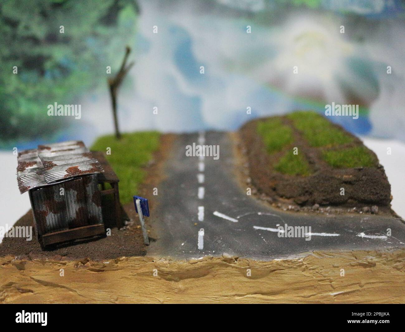 a close up of a diorama of a rice field scene and an old roadside house ...