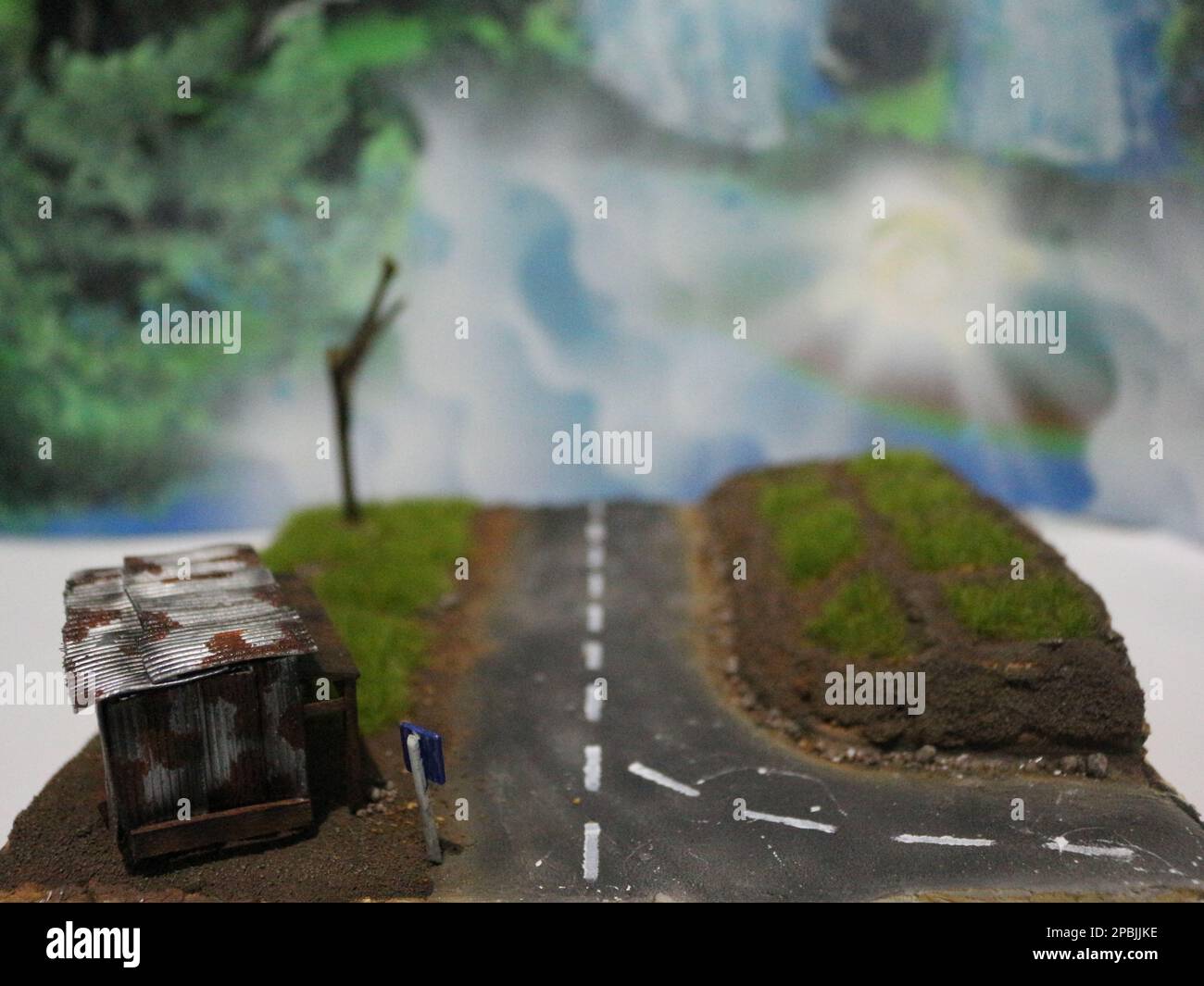 a close up of a diorama of a rice field scene and an old roadside house ...