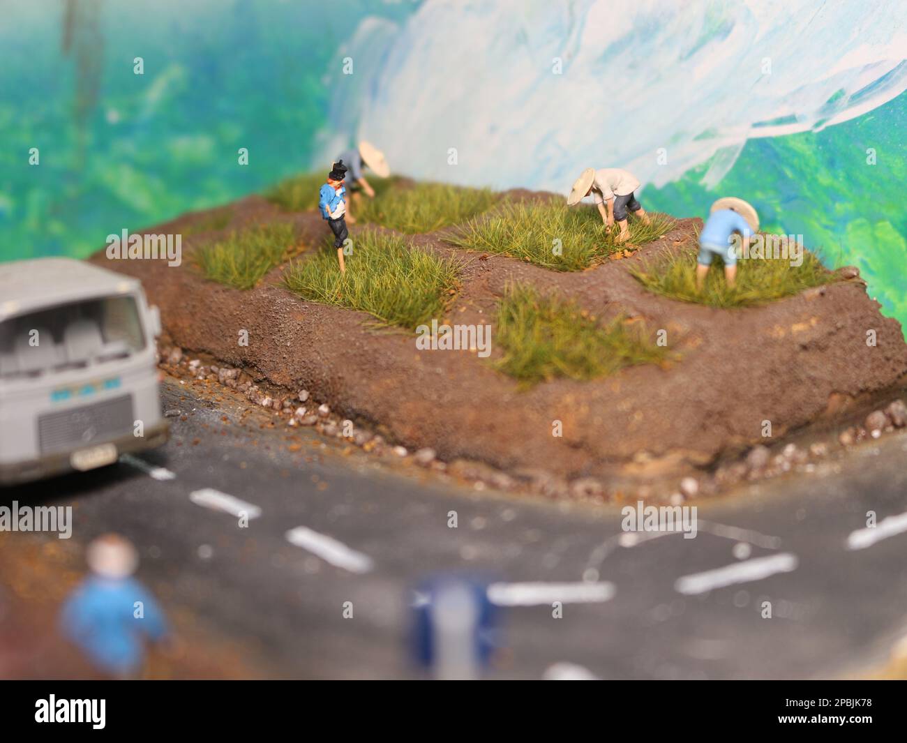 a miniature diorama of a rice field and a road as well as several ...