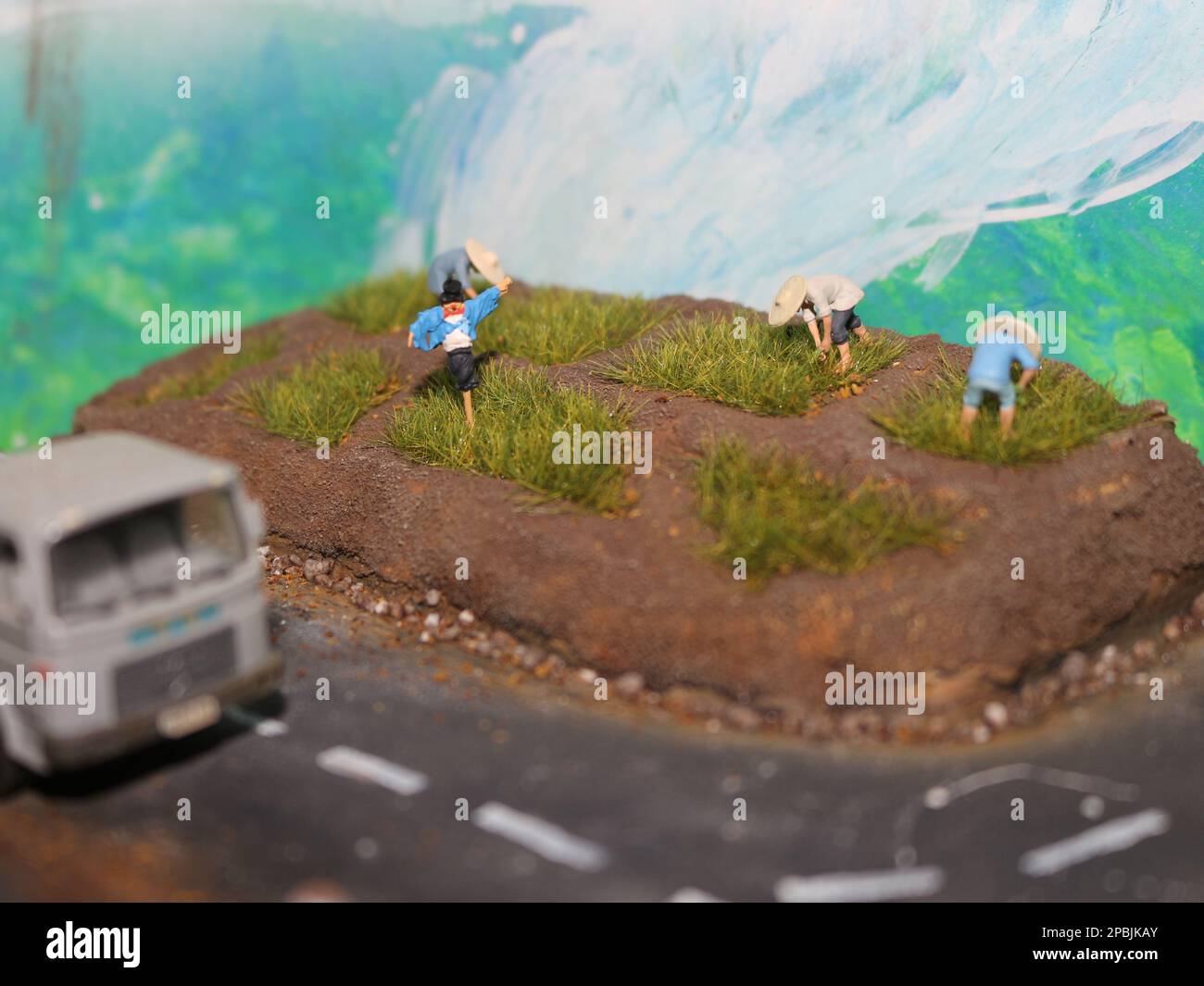 a miniature diorama of a rice field and a road as well as several ...