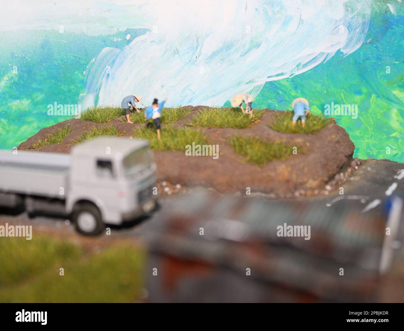 a miniature diorama of a rice field and a road as well as several ...