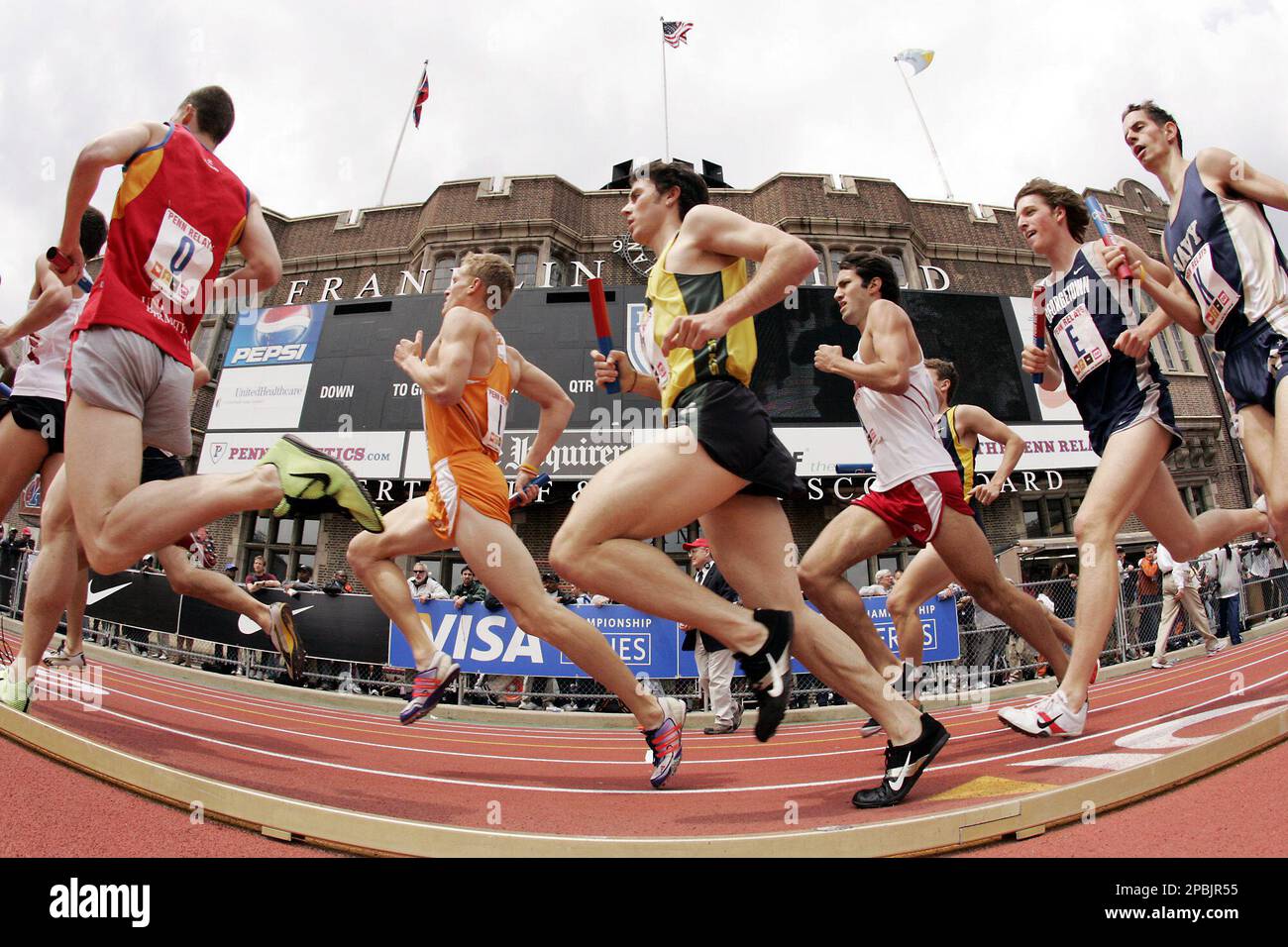 The first group of runners in the college men's 4-mile relay run at the ...