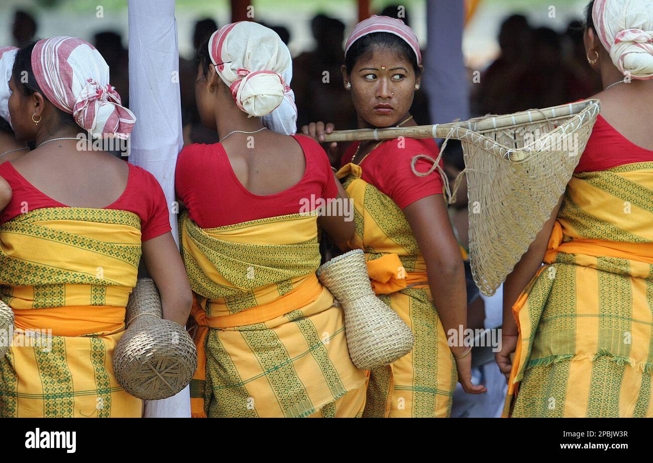 Bodo tribal girls in traditional costumes hold fishing tools before performing a fishermen dance ...