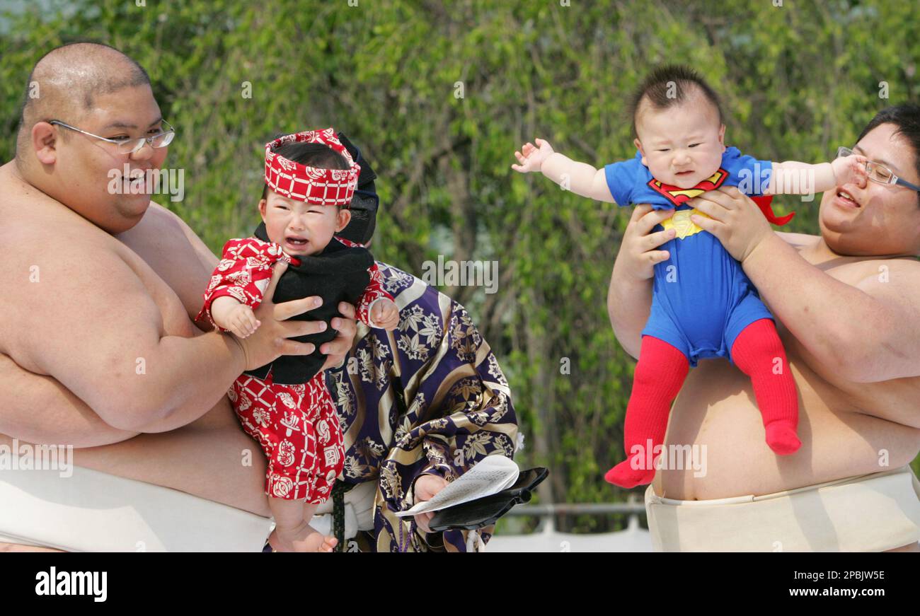 A coupld of toddlers Rion Yuine, left, and Seira Aoki, right, held by ...
