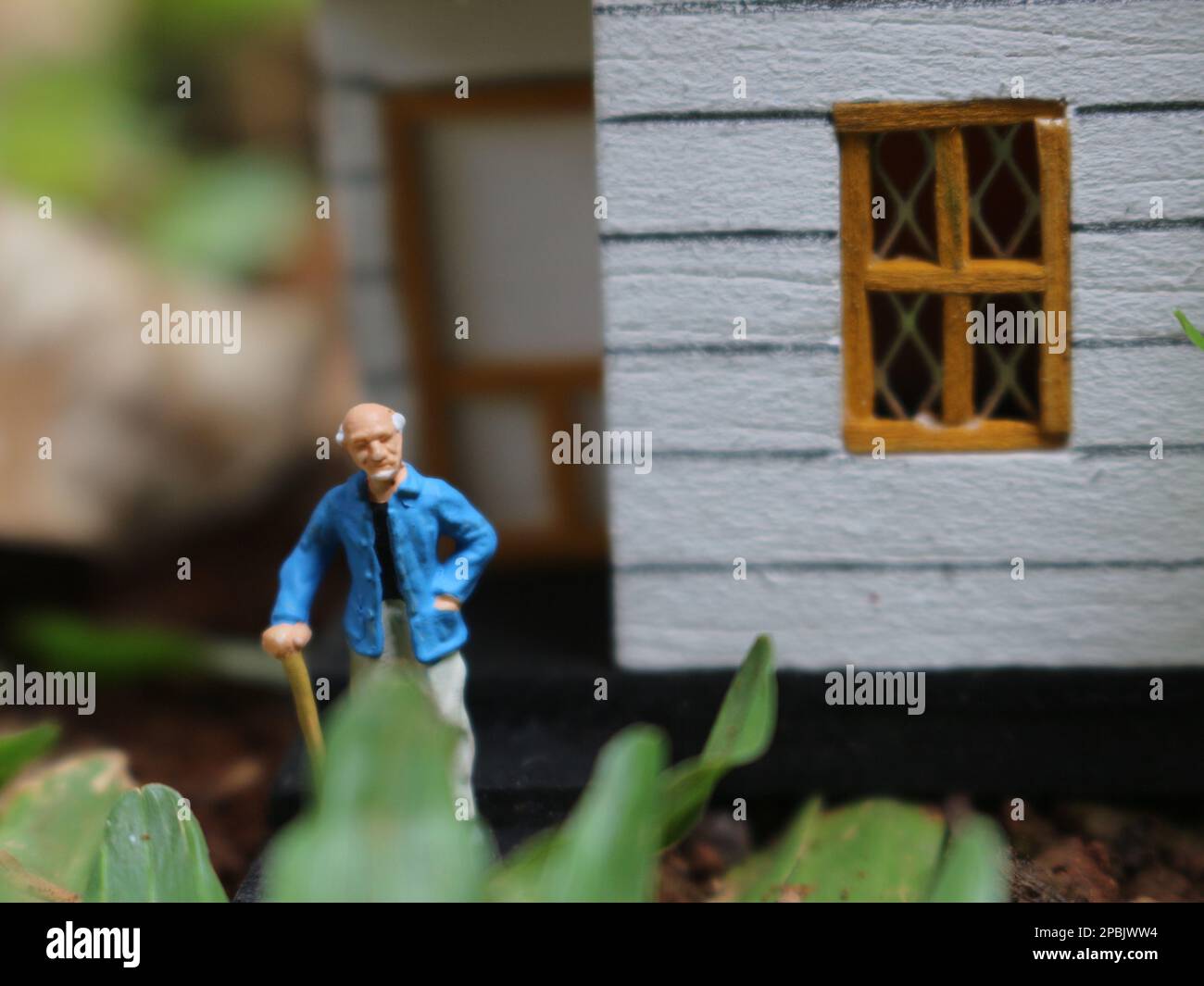 a close up of a miniature figure of an old man waiting in front of the ...