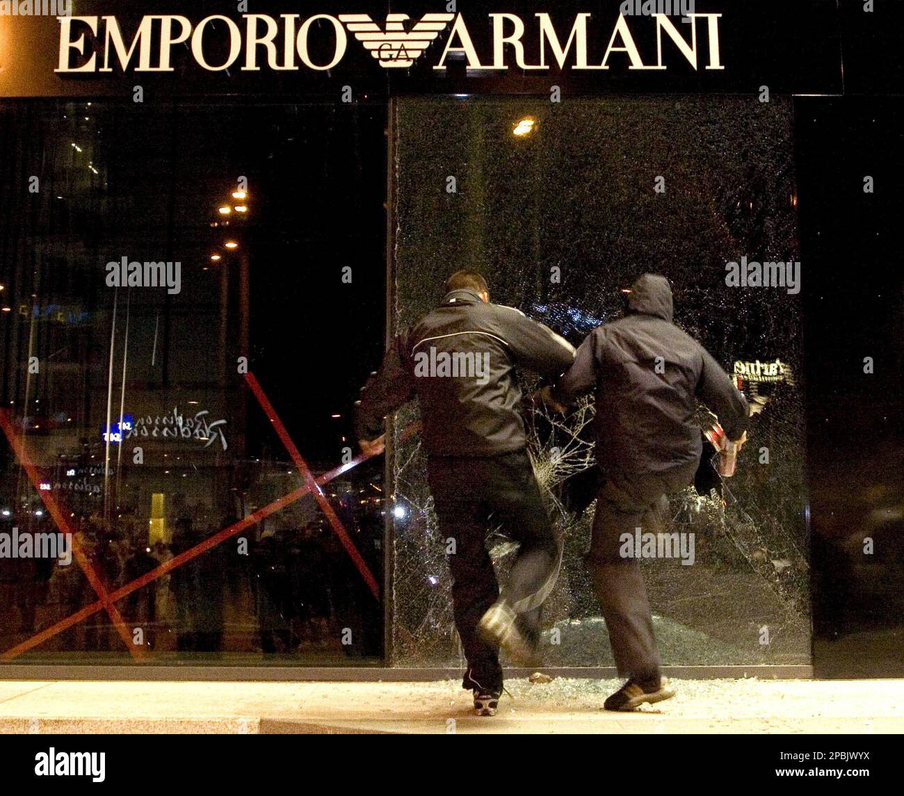 Rioters smash a shop window in central Tallinn during the second night ...