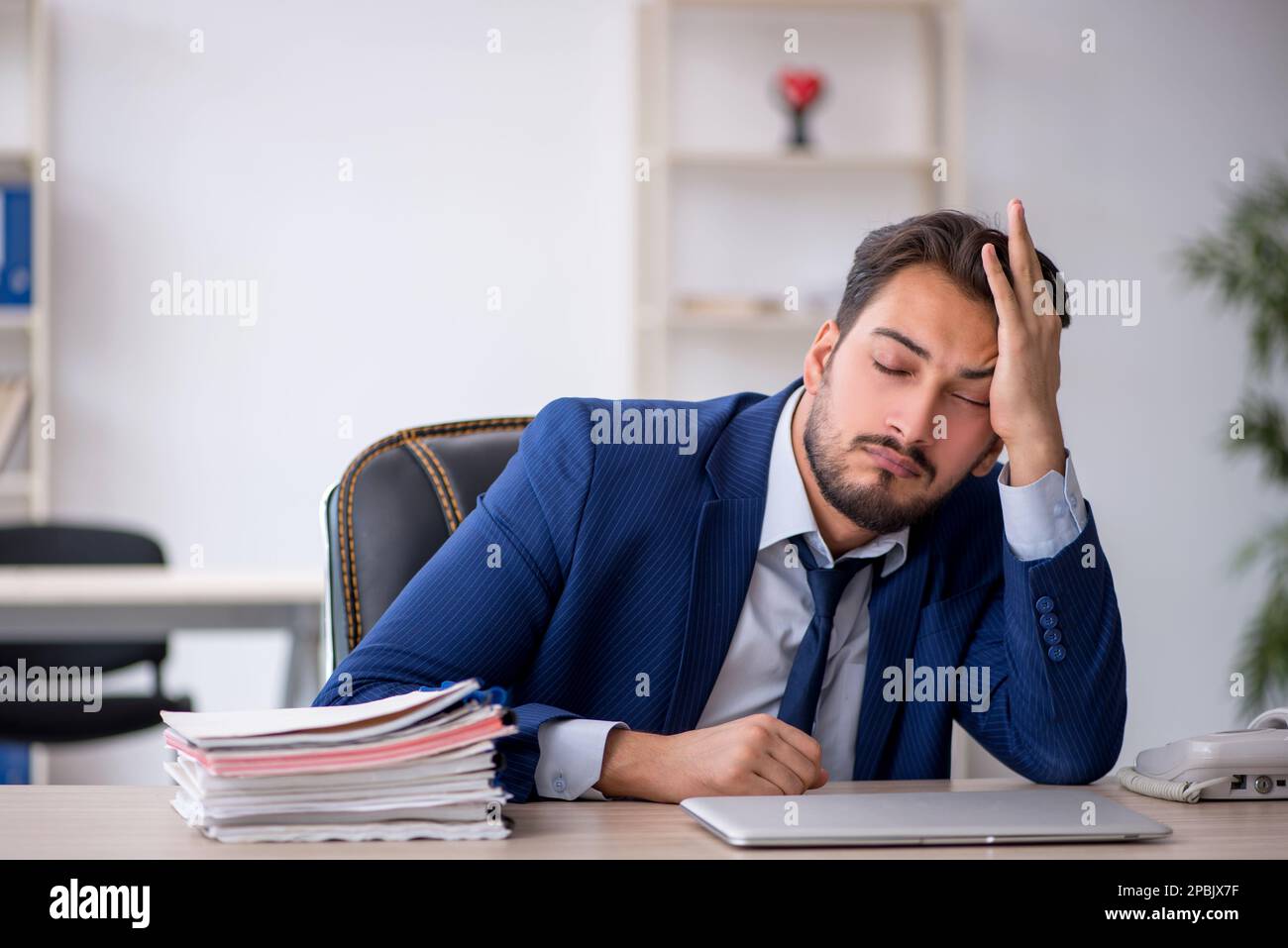 Young businessman employee extremely tired at workplace Stock Photo - Alamy
