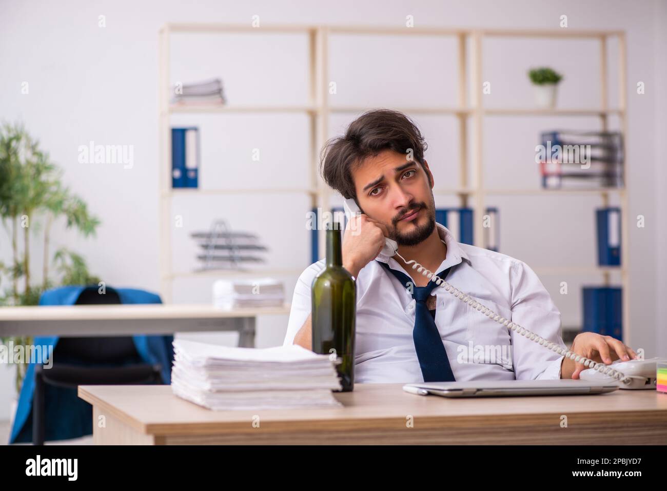 Male alcohol addicted employee sitting in the office Stock Photo - Alamy