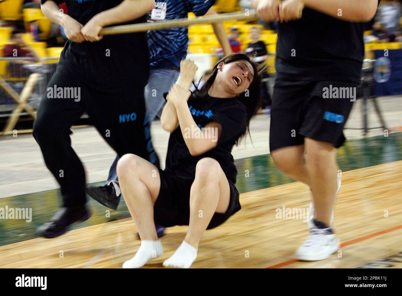 Reana Lawrence, center, slips off of the stick as she is carried around ...