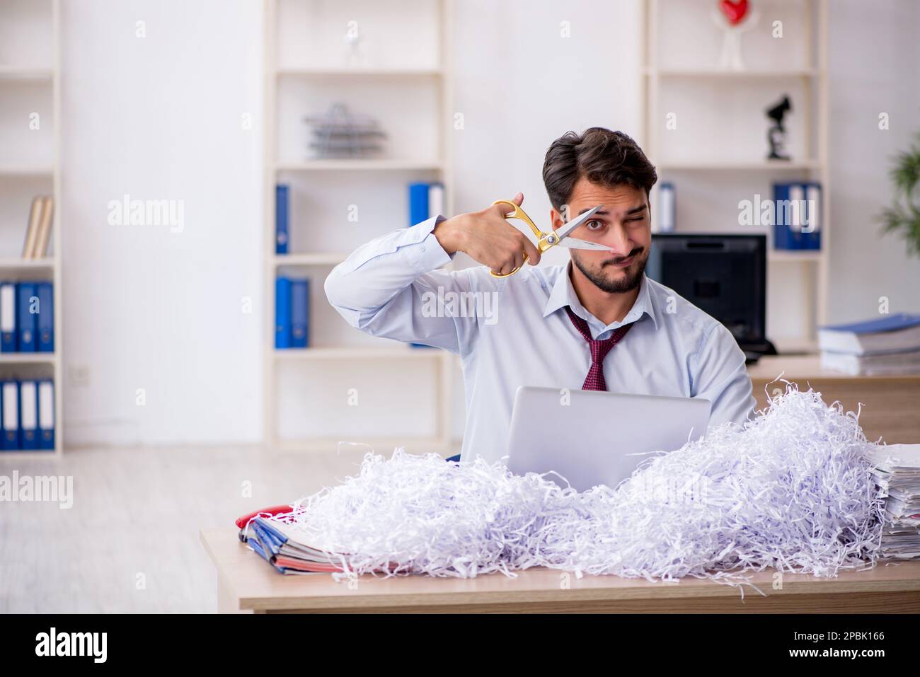 Young businessman employee and a lot of cut papers in the office Stock ...
