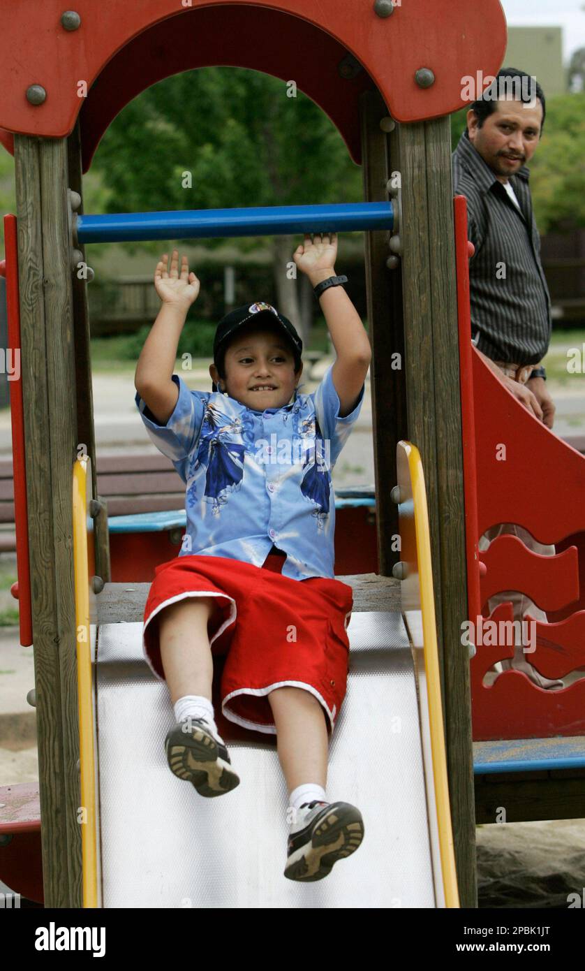 Kebin Noe Reyes, 7, plays as his father Noe Ariel Reyes, right, looks ...