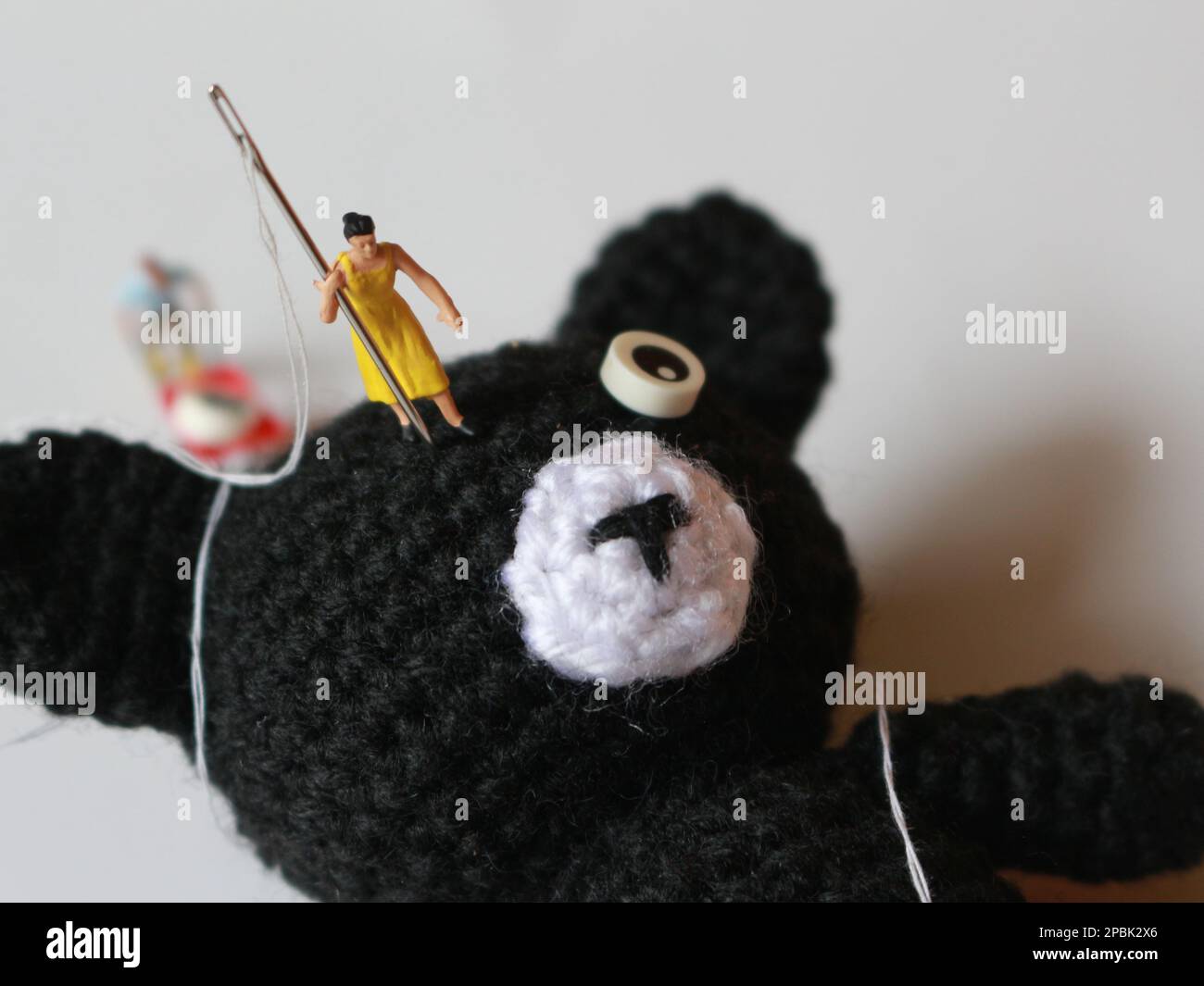 a close up of a miniature tailor figure sewing on a doll's eyes Stock ...