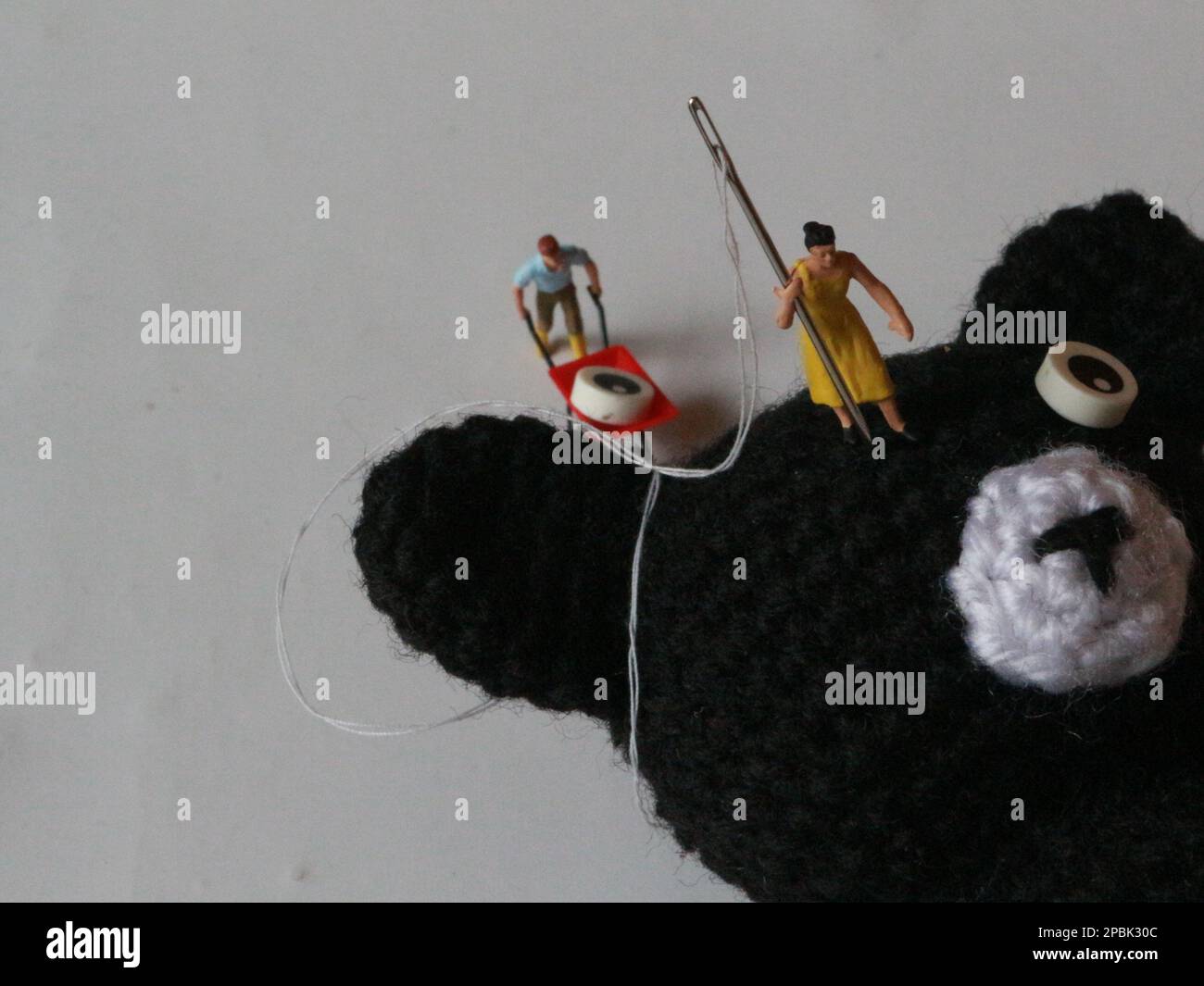 a close up of a miniature tailor figure sewing on a doll's eyes Stock ...