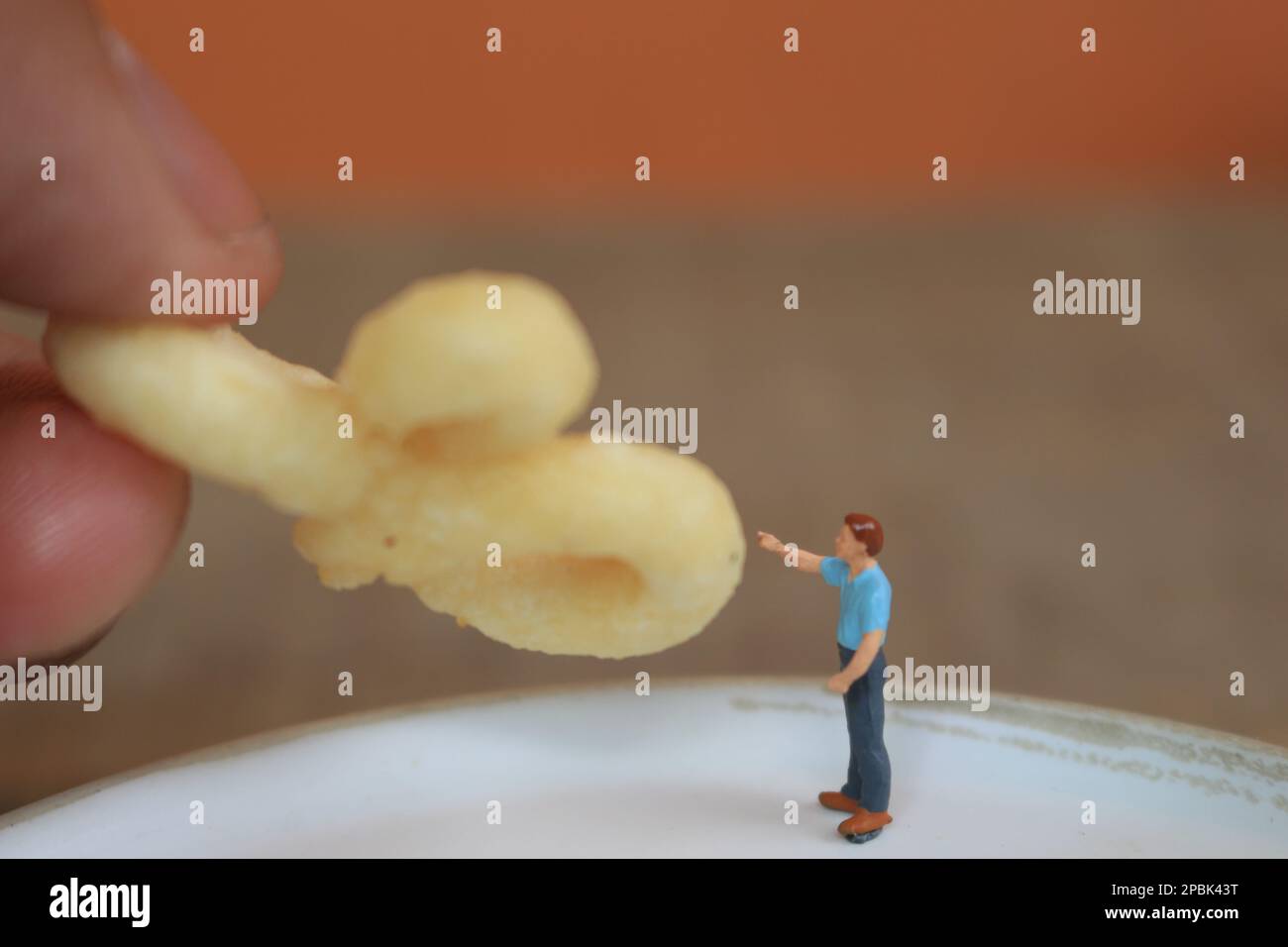 miniature figure of a child interacting with human hands giving food ...