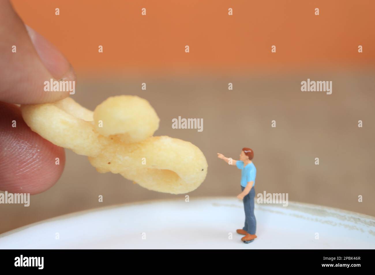 miniature figure of a child interacting with human hands giving food ...