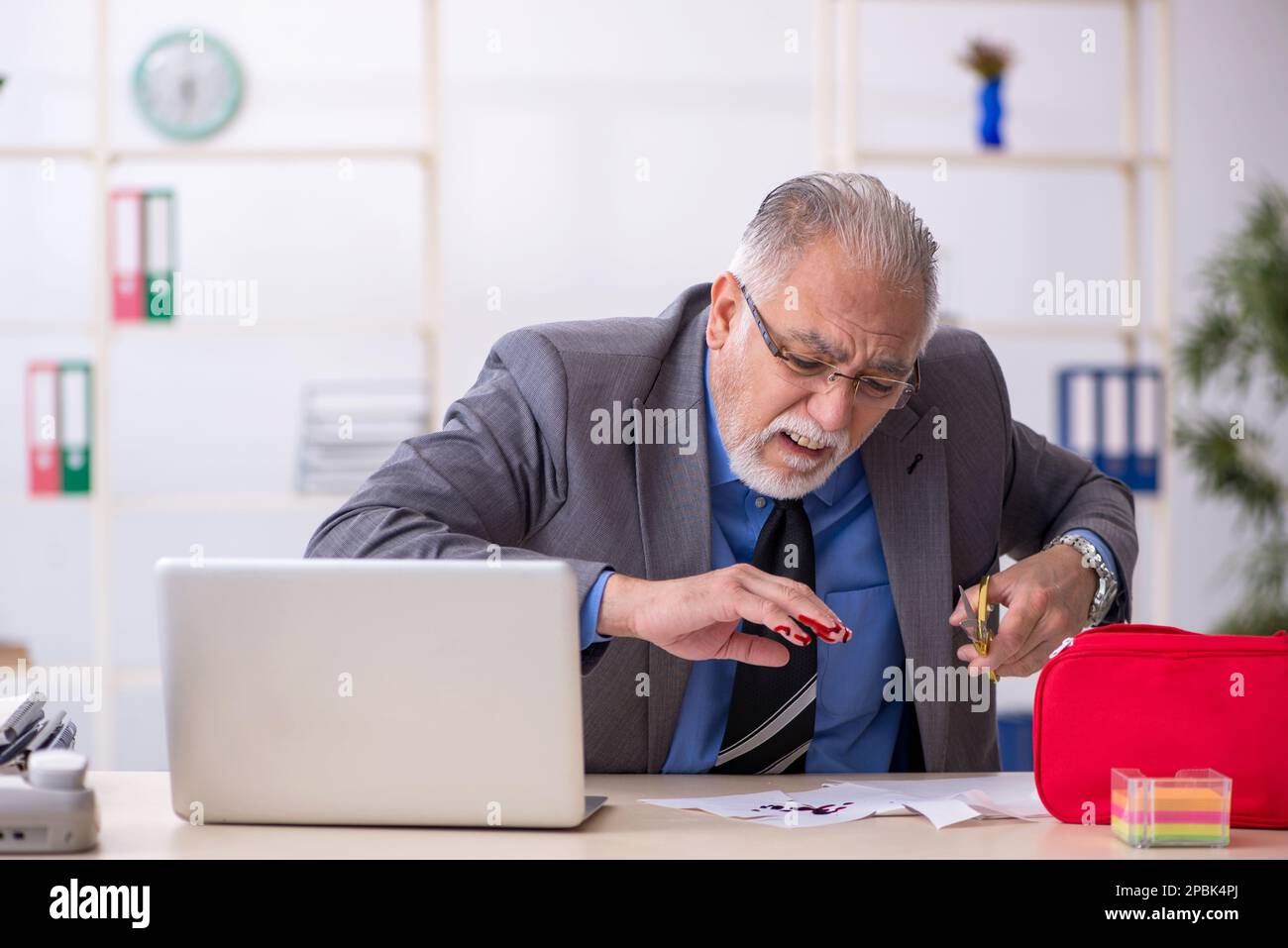 Old businessman employee cutting his hand at workplace Stock Photo - Alamy