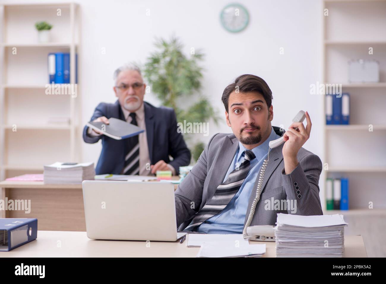 Two male employees working at workplace Stock Photo - Alamy