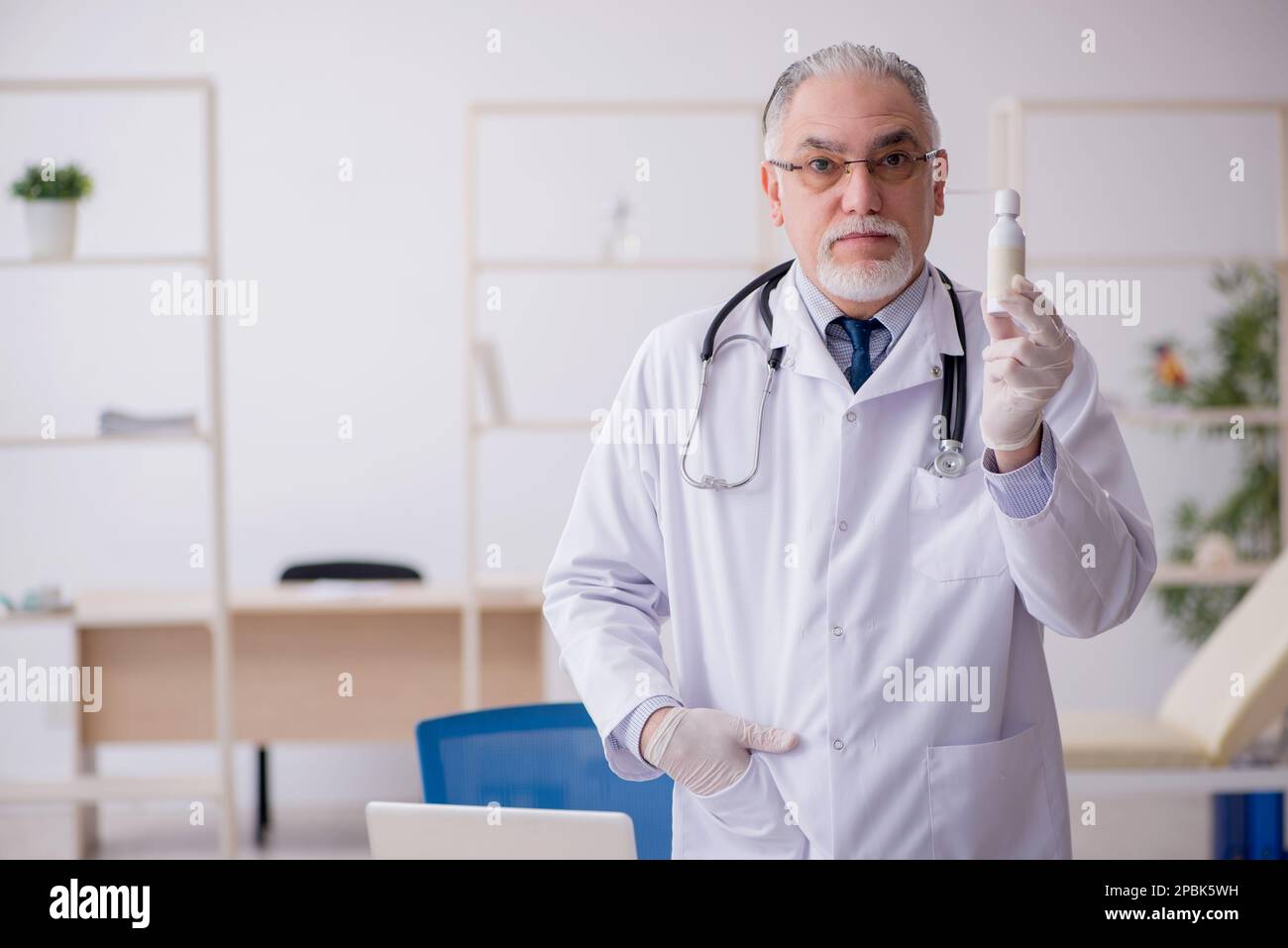 Old doctor working in the clinic Stock Photo - Alamy