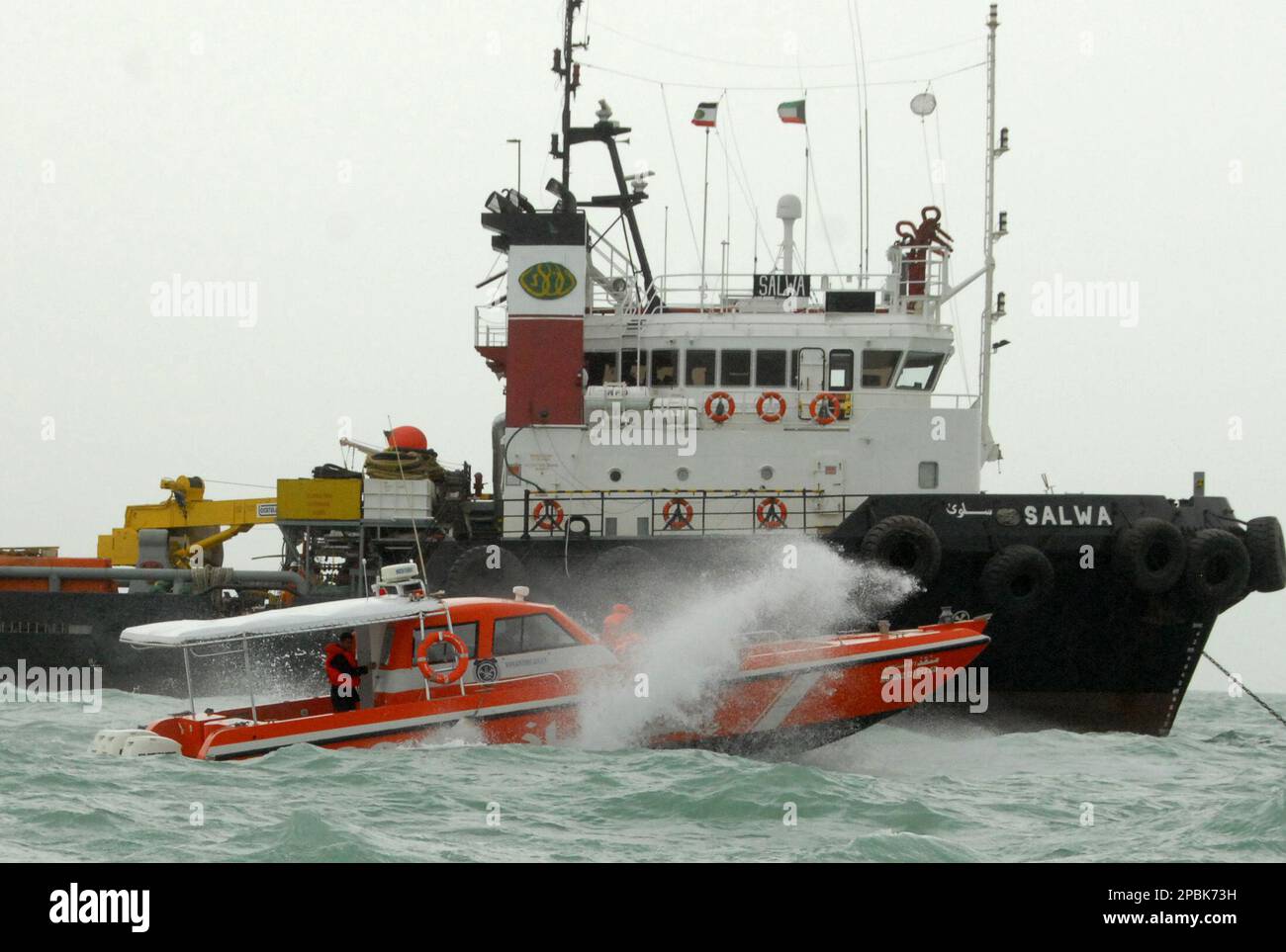 A Kuwait Fire Services rescue power boat approaches a floating service ...