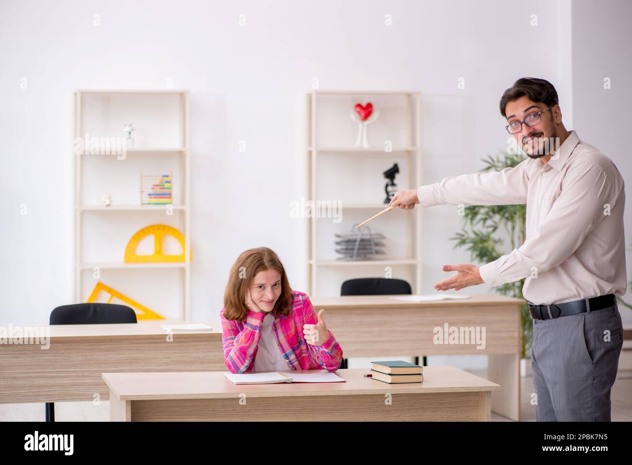 Young teacher and redhead girl in the classroom Stock Photo - Alamy