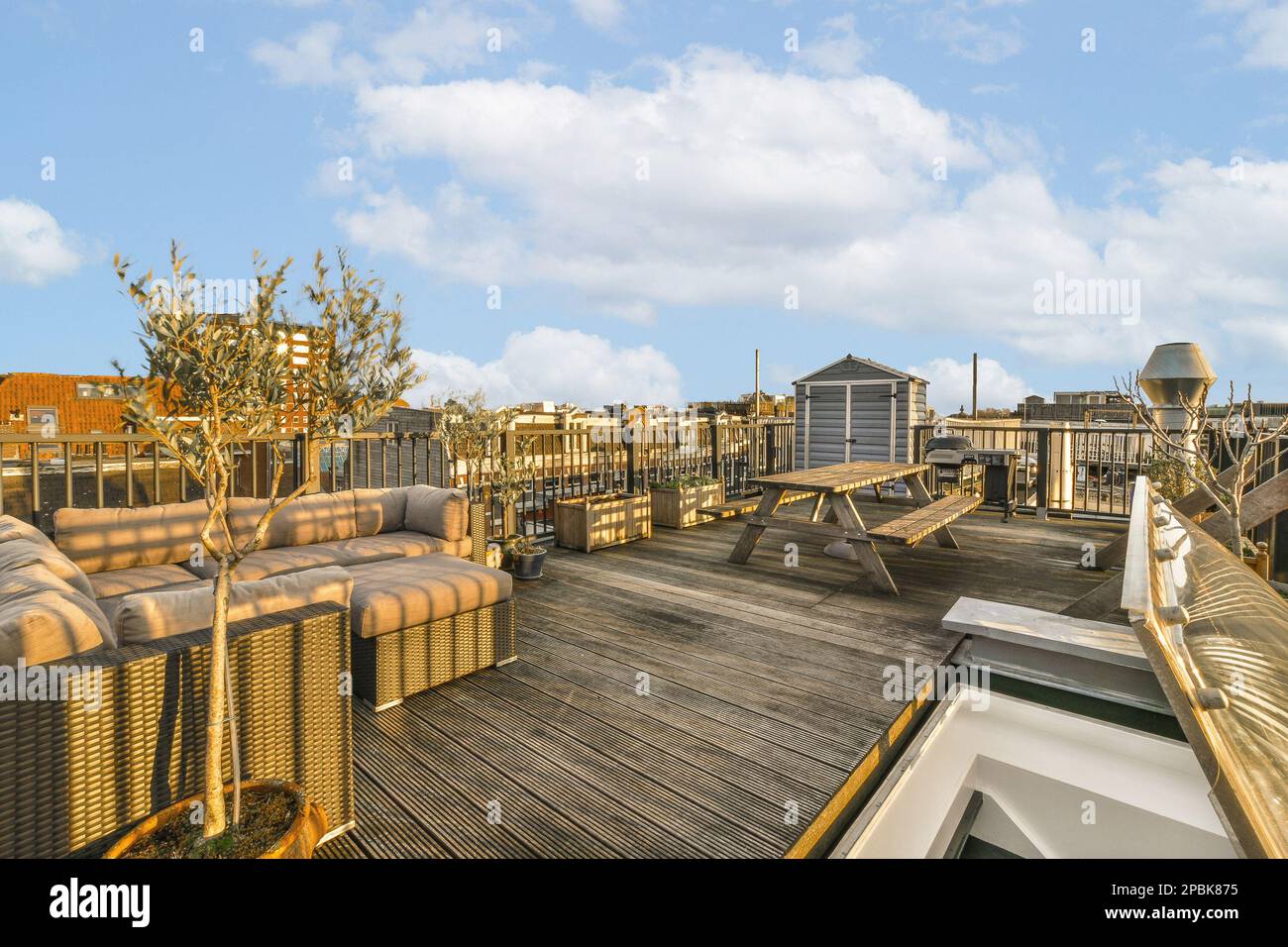 a rooftop area with some chairs and umbrellas on the deck, in front of ...