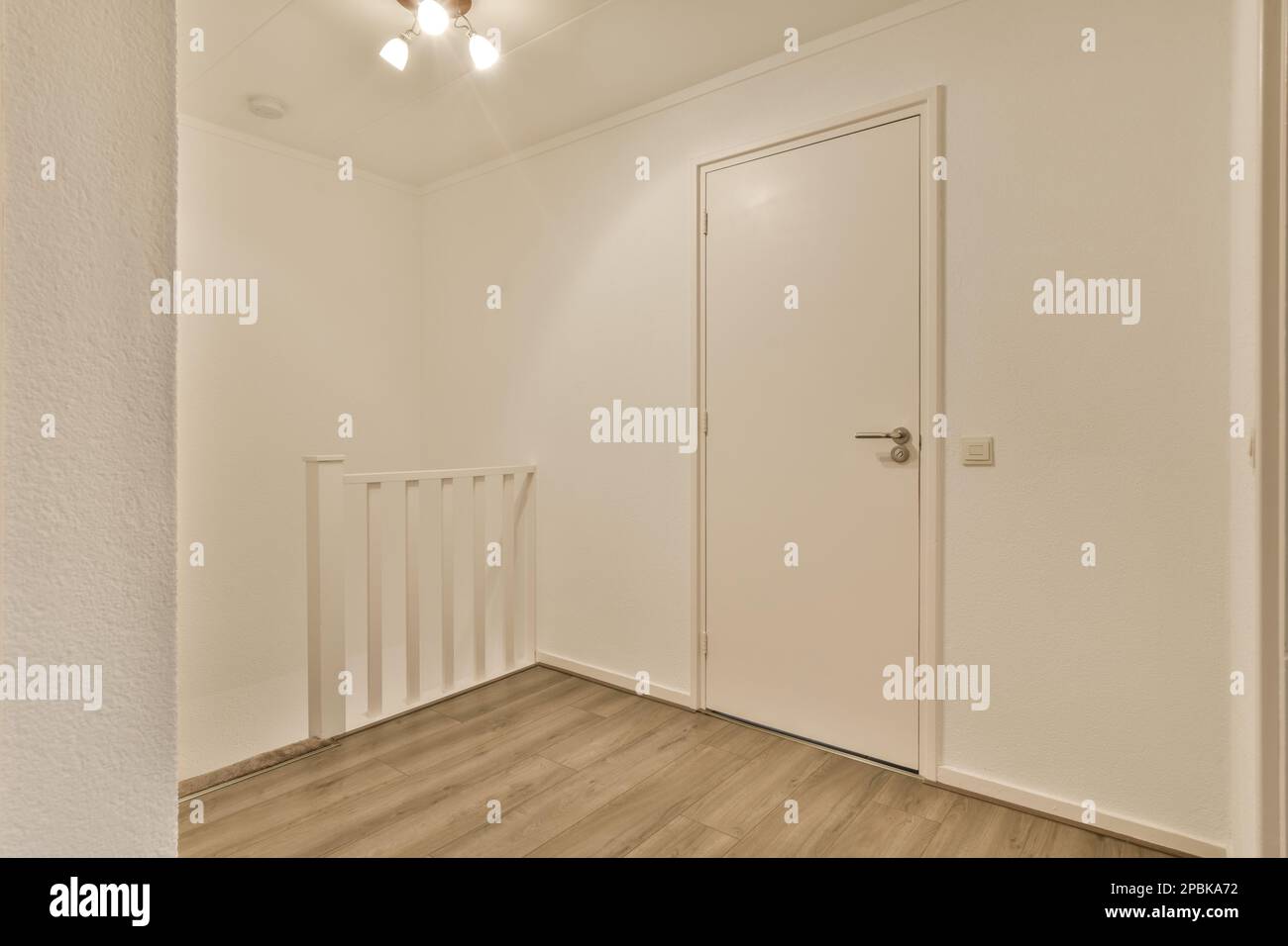 an empty room with white walls and wood flooring the door is open to ...